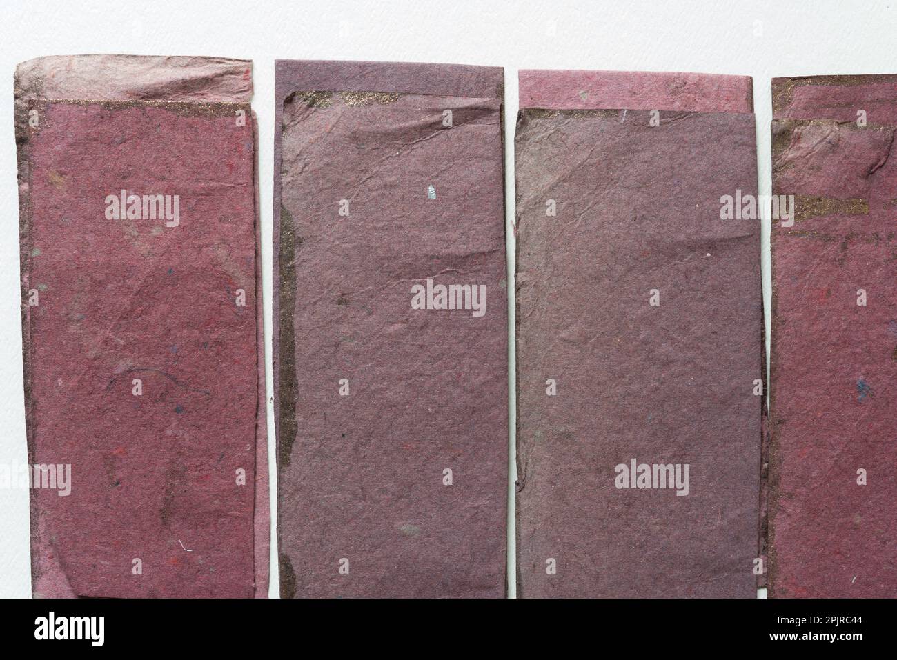 rough textured red brown crafting paper sheets arranged on a blank ...