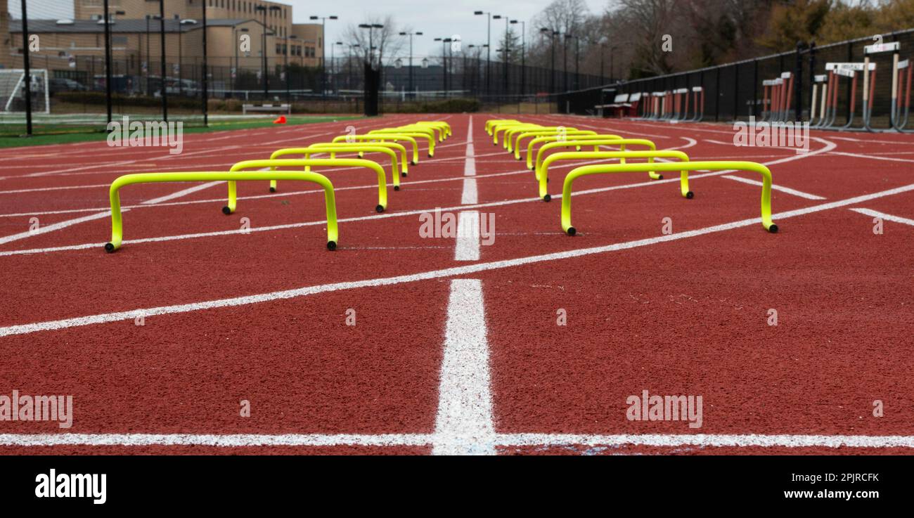 Two rows of six inch yellow hurdles set u in lanes on a track Stock ...