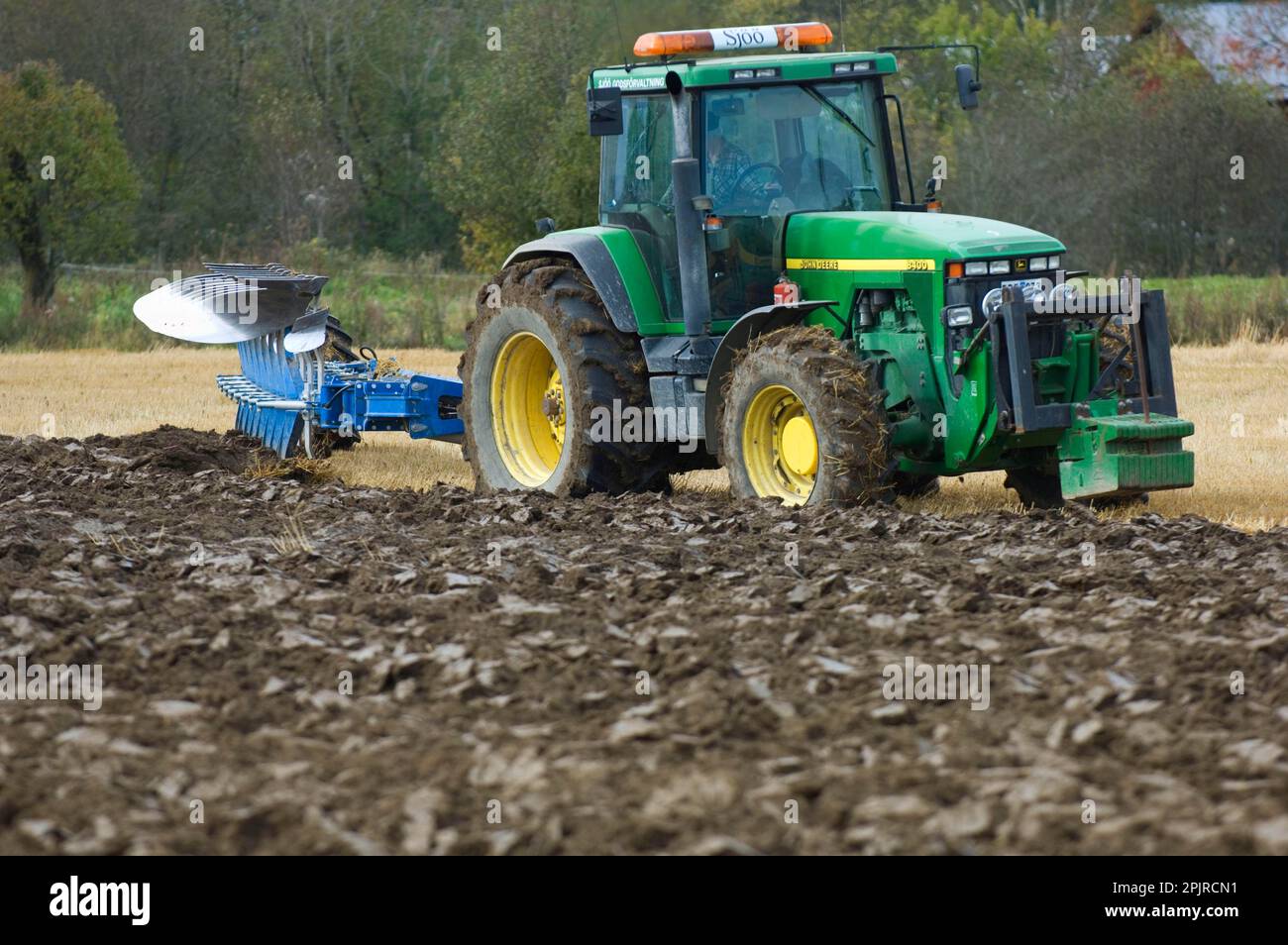 John Deere 8400 tractor with eight-furrow reversible plough, ploughing ...