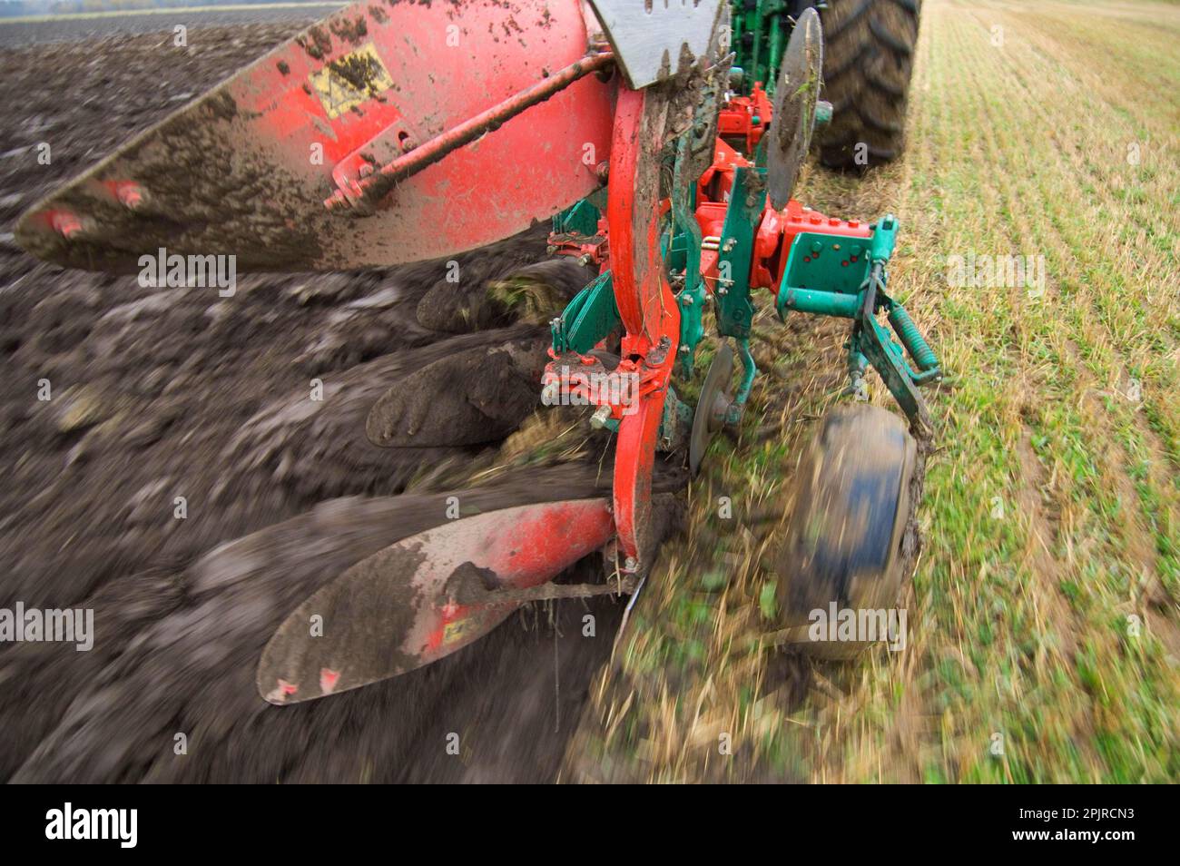 Close-up of a four-furrow reversible plough, ploughing a stubble field ... Close-up of a four-furrow reversible plough, ploughing a stubble field ...