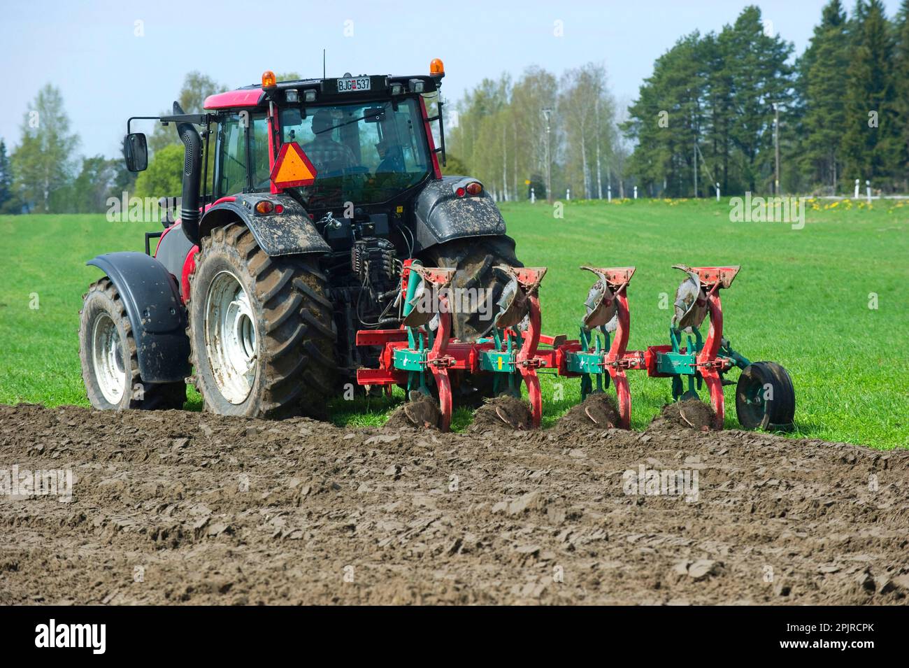 Valtra tractor ploughs field with four-furrow reversible plough, Sweden ...