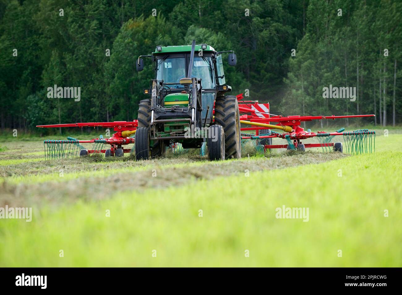 Silage harvesting, John Deere tractor with double tedder, turning cut ...