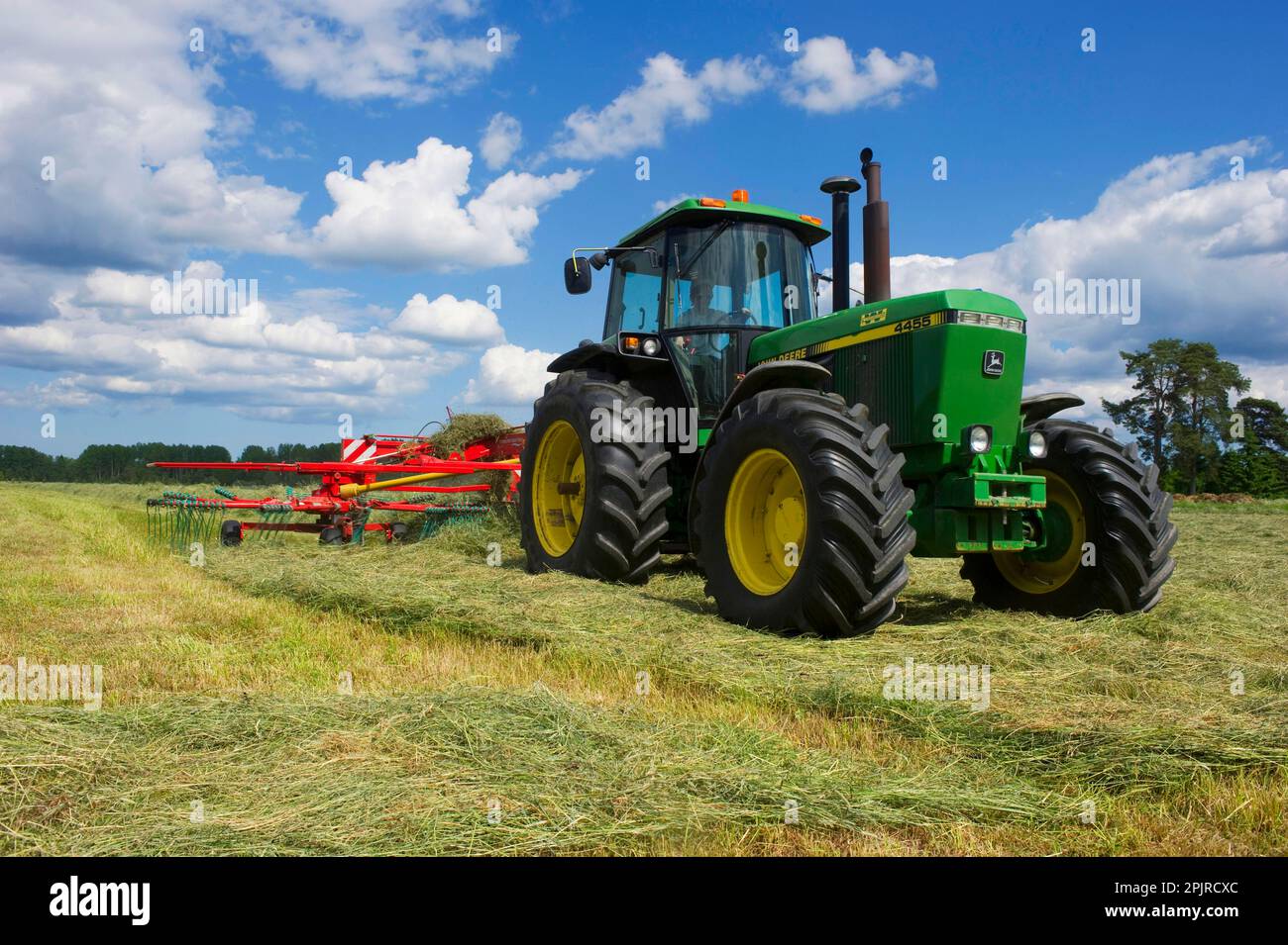 John Deere 4455 tractor and double turner, turning cut grass for silage ...