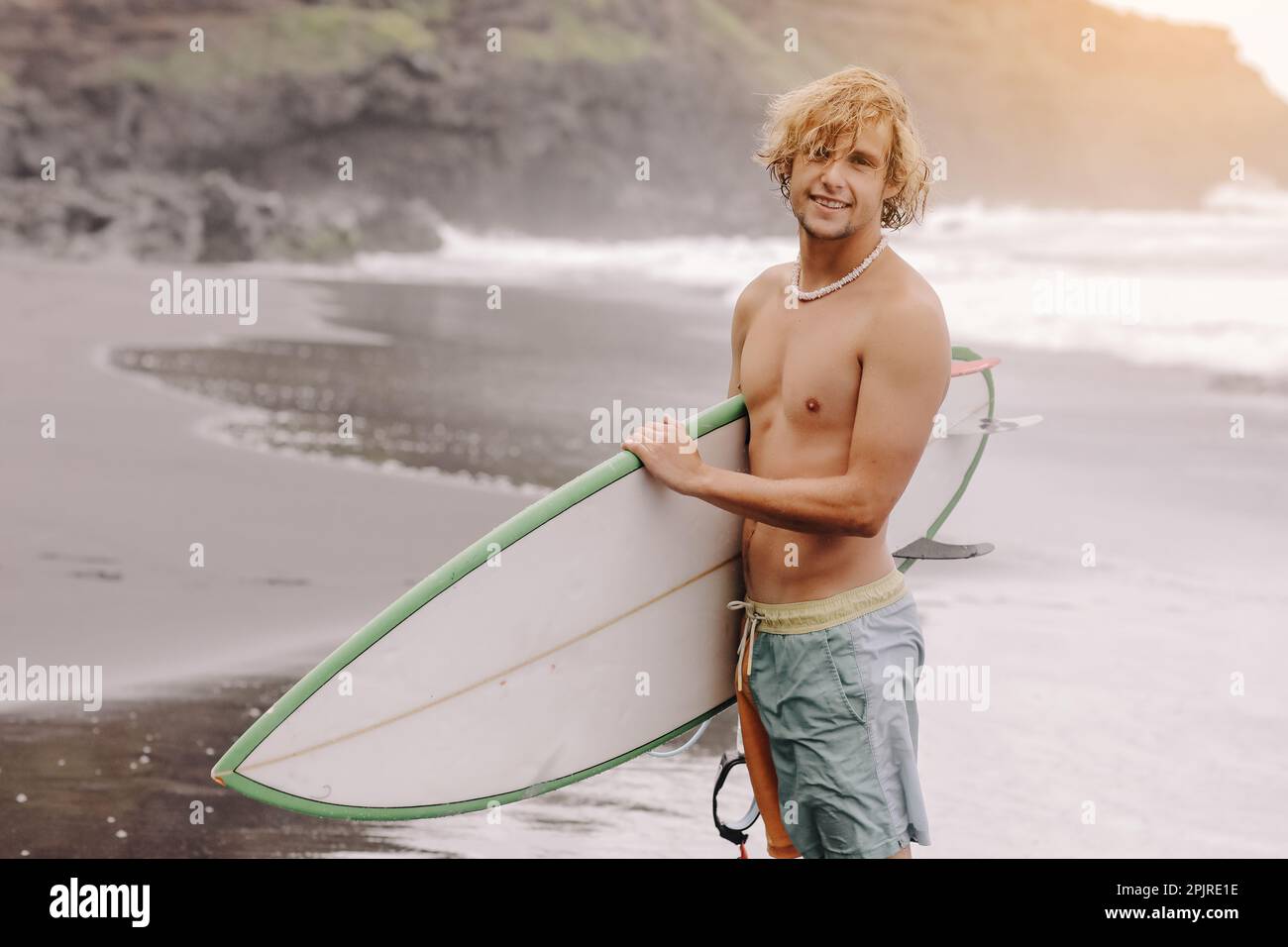 Handsome fit young blond man with mock up surfboard waits for wave to ...