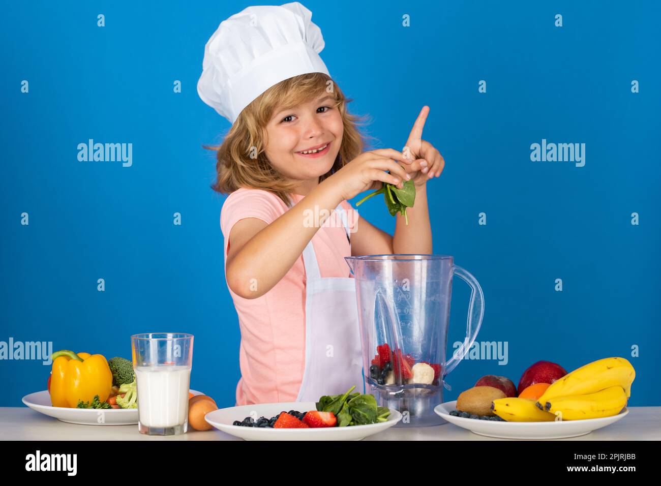 Child chef dressed cook baker apron and chef hat isolated on studio ...