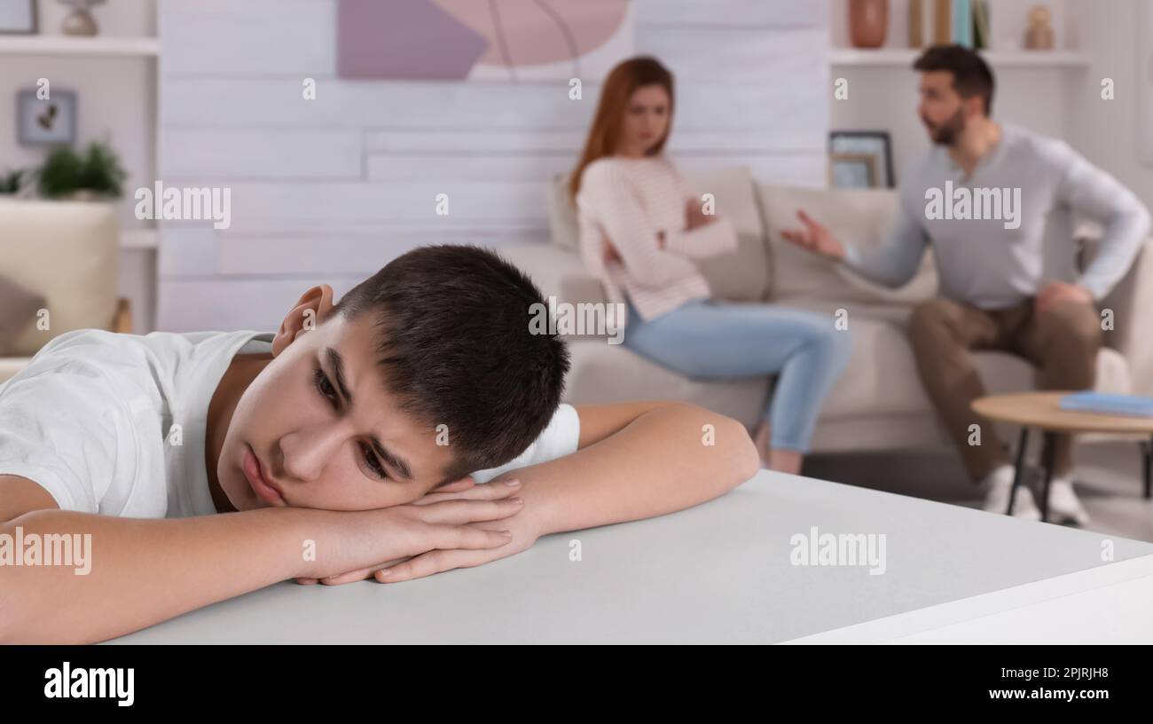 Couple arguing at home, focus on their unhappy teenage boy. Problems in family Stock Photo - Alamy