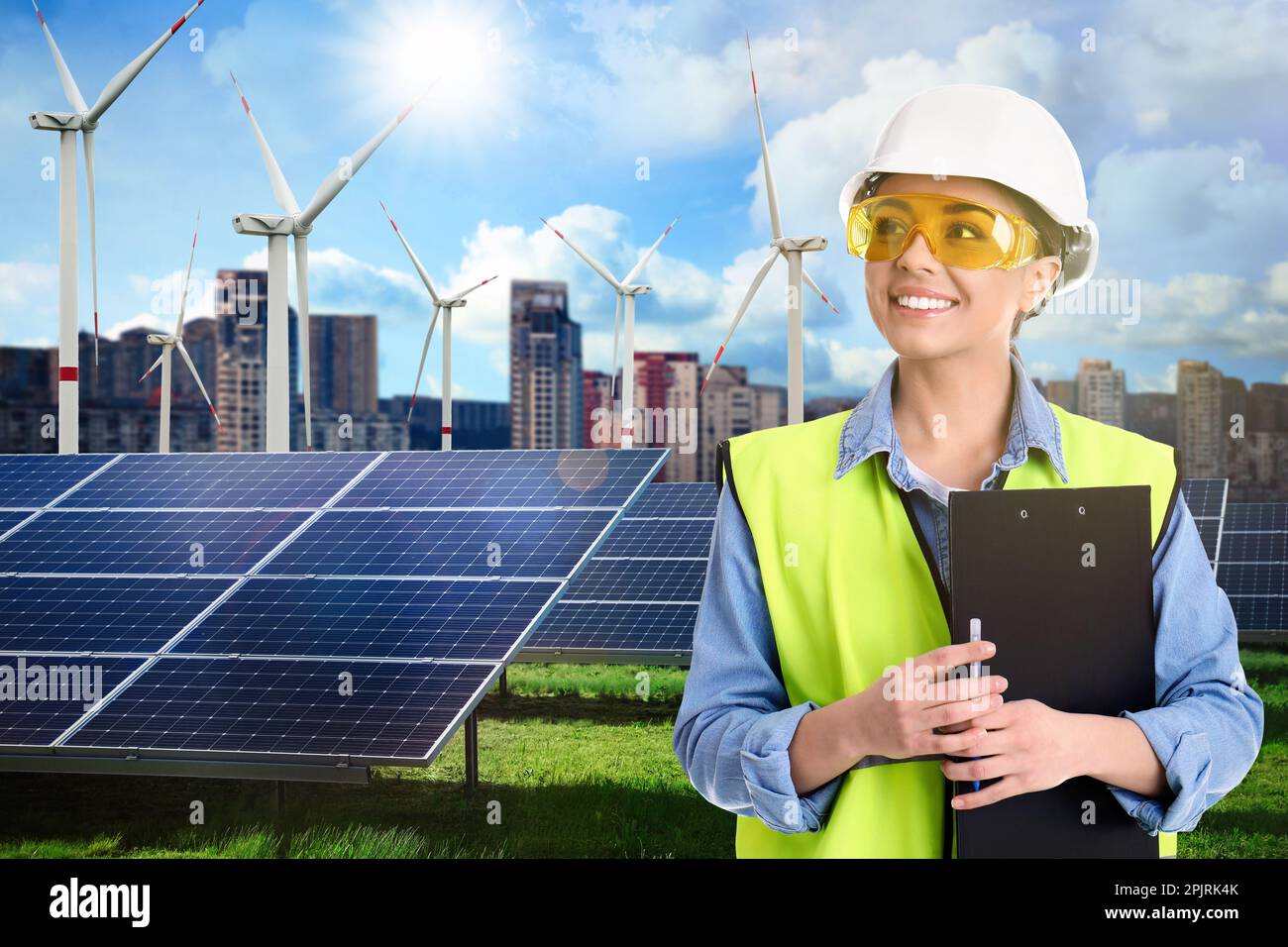 Industrial engineer in uniform and view of solar panels and wind energy ...