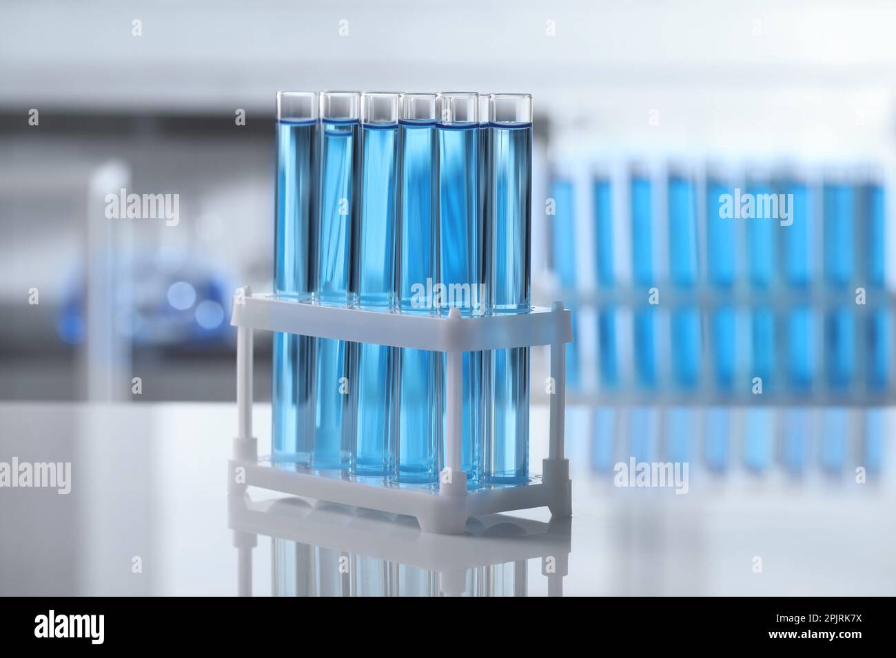Test tubes with light blue liquid on table in laboratory Stock Photo ...