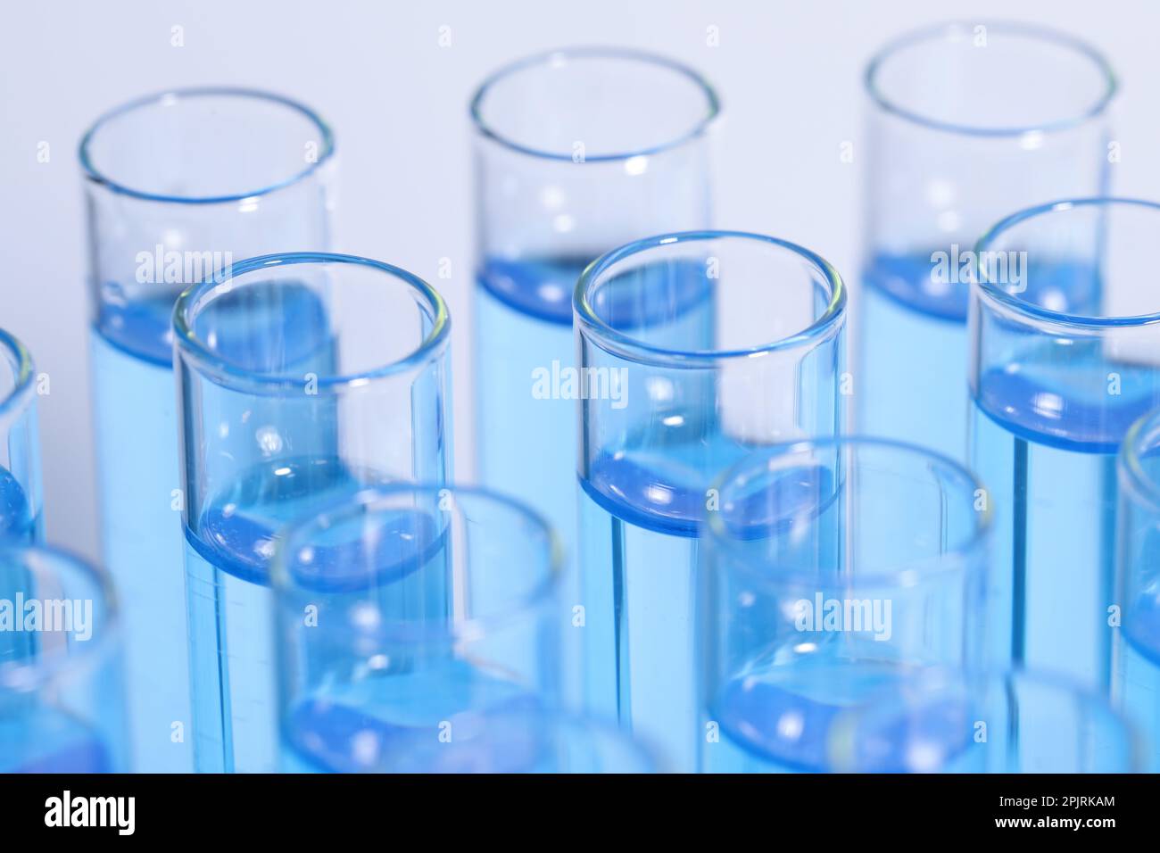 Test tubes with reagents on light blue background, closeup. Laboratory ...