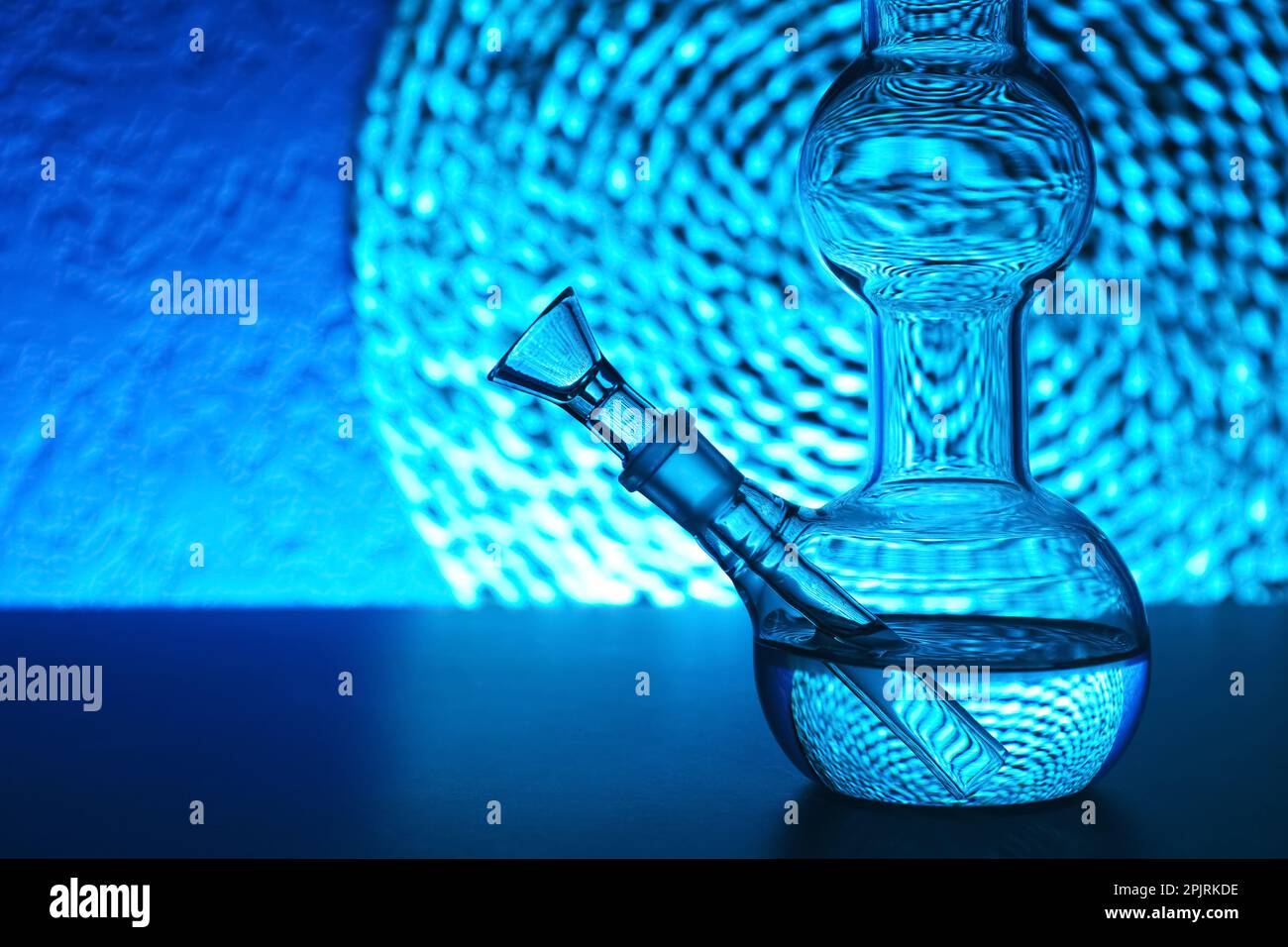 Closeup view of glass bong on table, space for text. Smoking device ...