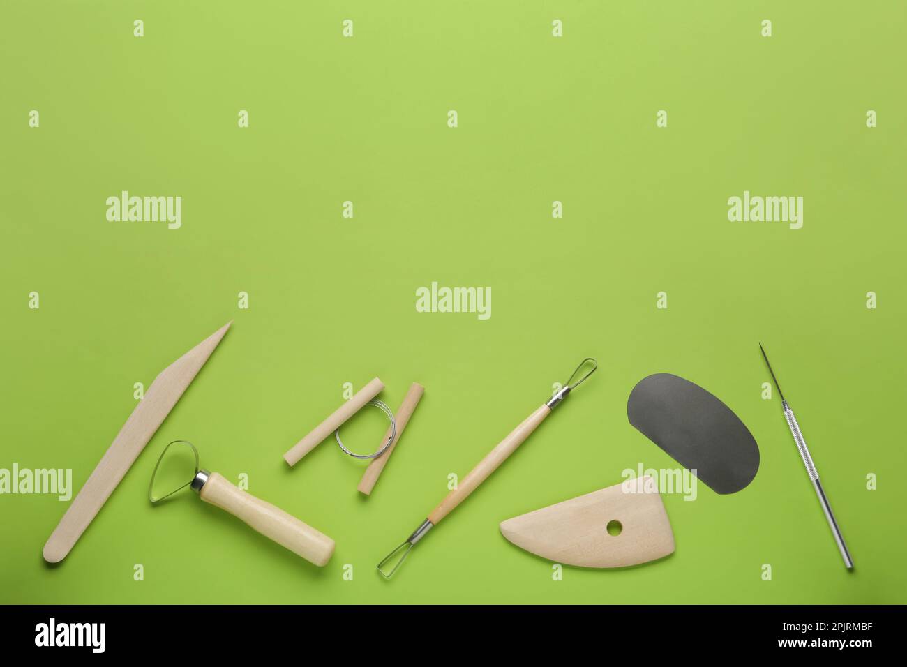 Set of clay modeling tools on green background, flat lay. Space for ...