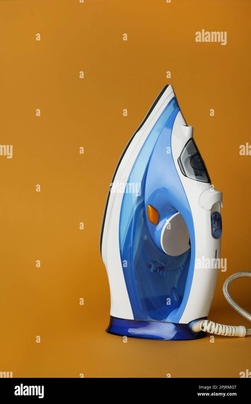 One modern iron on orange background. Home appliance Stock Photo - Alamy