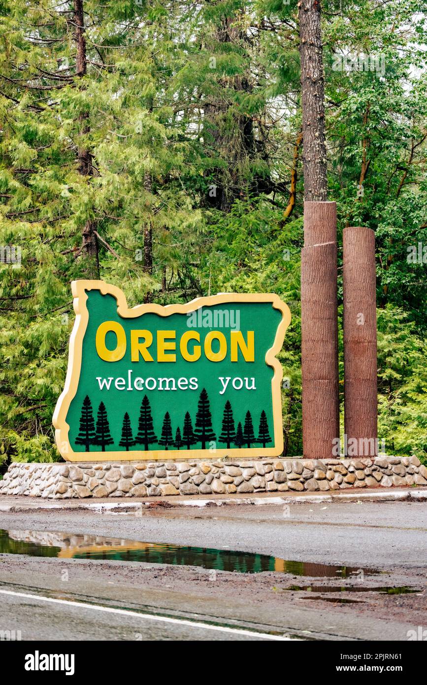 Wide vertical image of Oregon welcomes you sign on Redwood Highway with ...