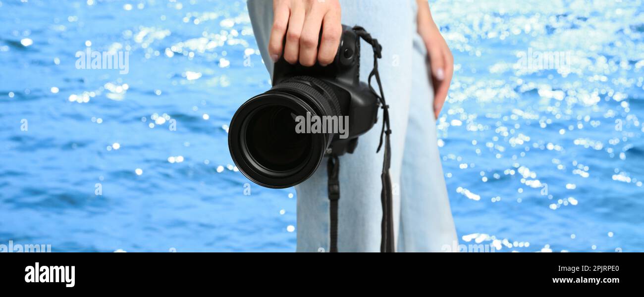 Professional photographer with modern camera and blurred view of ...