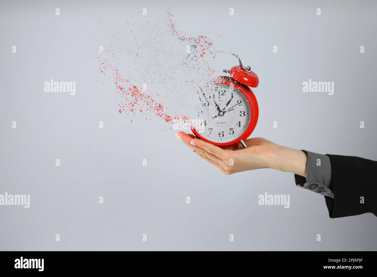 Time is running out. Woman holding vanishing red alarm clock against ...