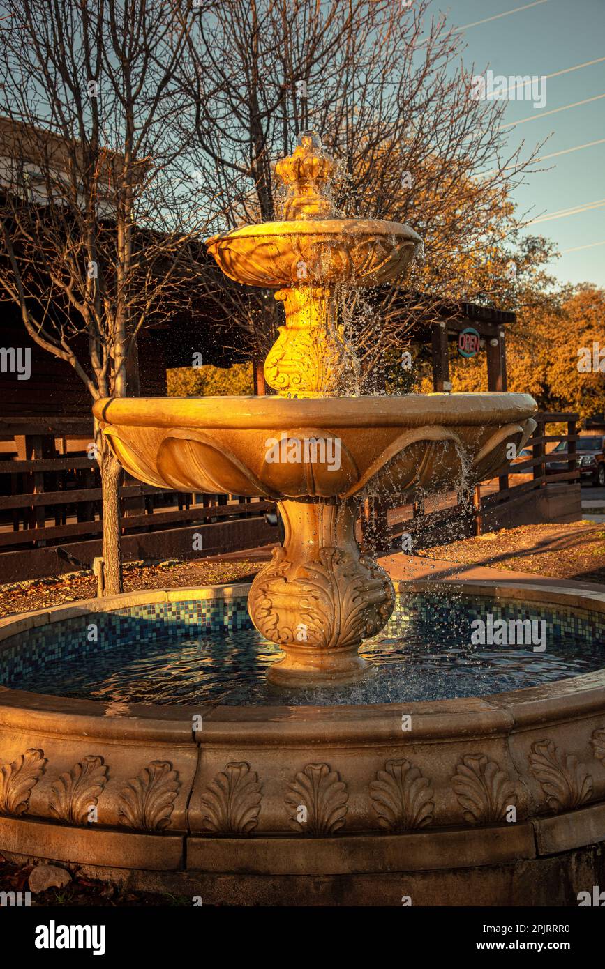 Water flows in an outdoor two tier water fountain with basin pool ...