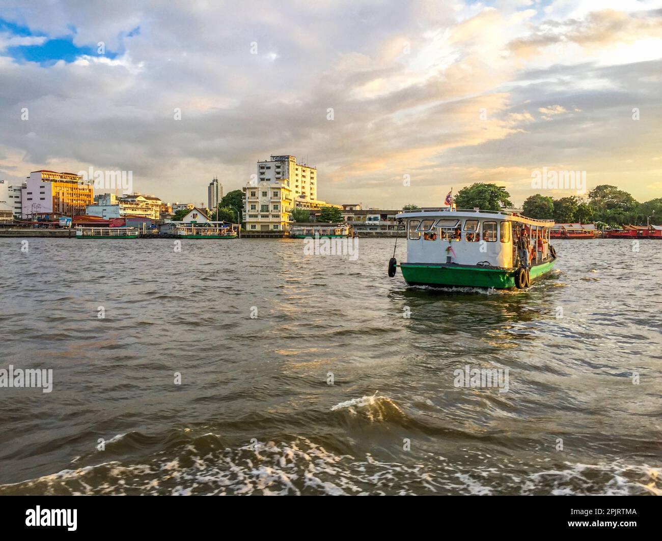 Ferry boat in Bangkok on the river with buildings in the background on ...