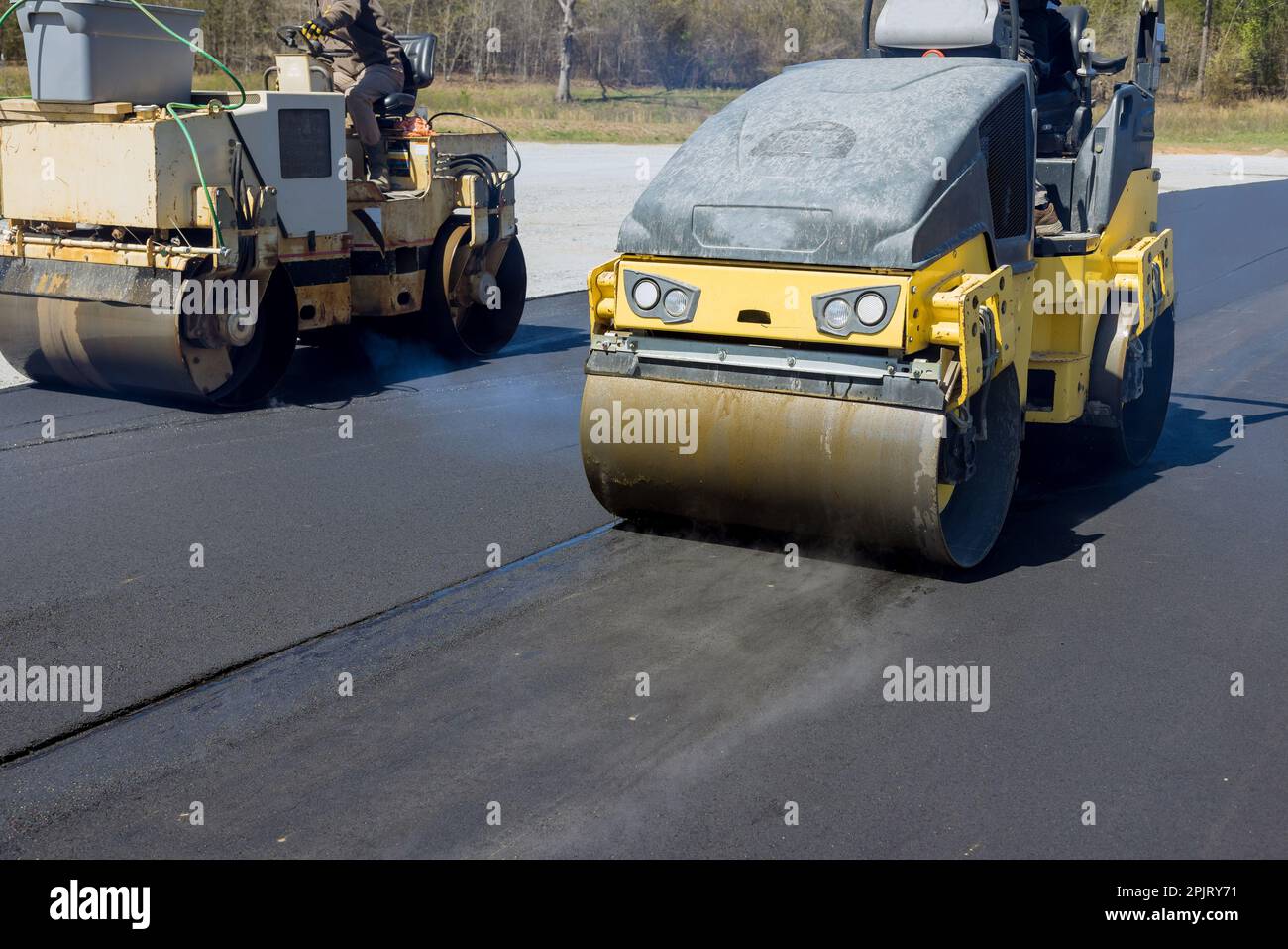 Worker operating vibratory road roller compactor process machine laying ...