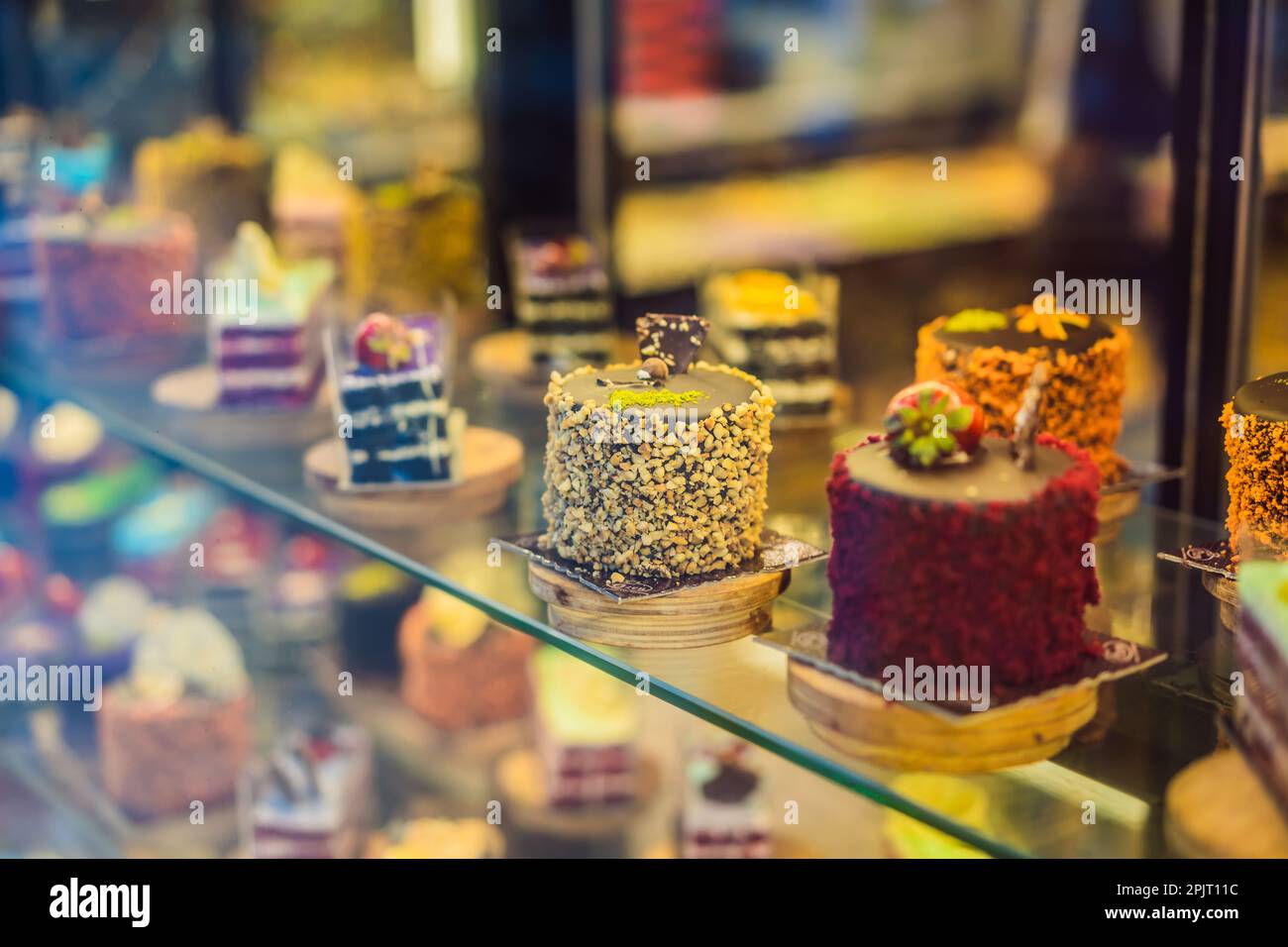 Different types of cakes in pastry shop glass display Stock Photo - Alamy