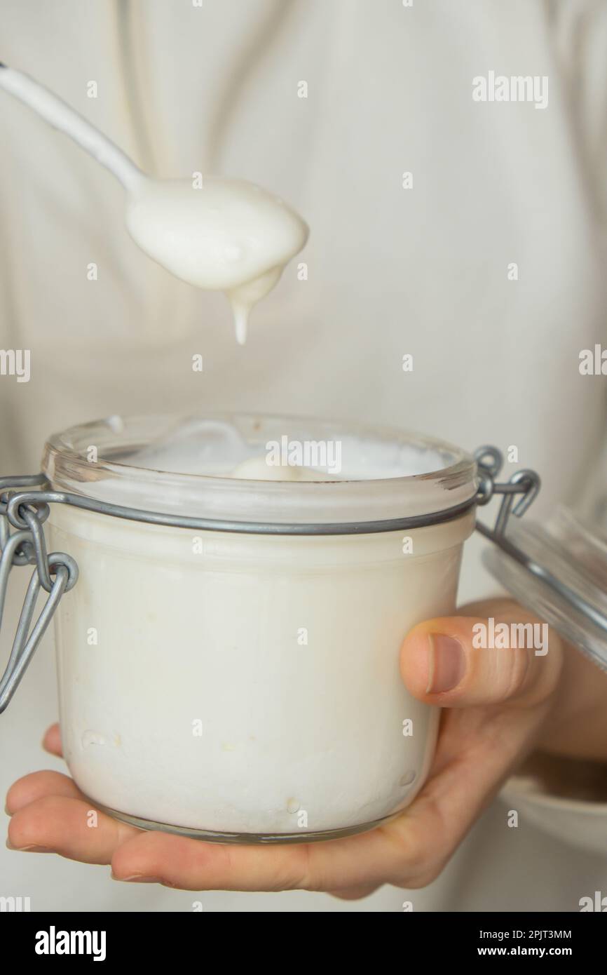 Unrecognizable woman eating from Glass jar natural organic homemade ...