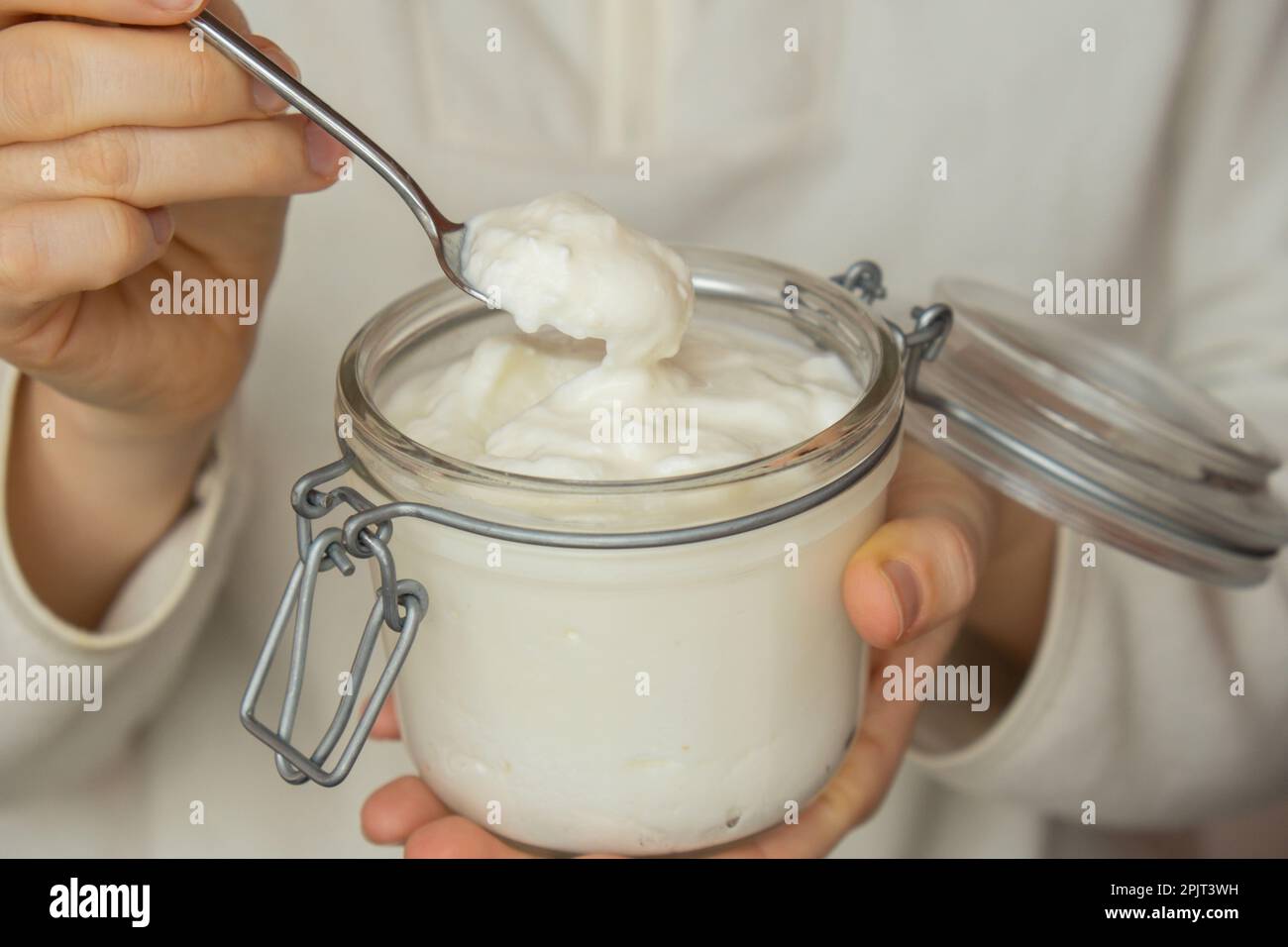 Unrecognizable woman eating from Glass jar natural organic homemade ...