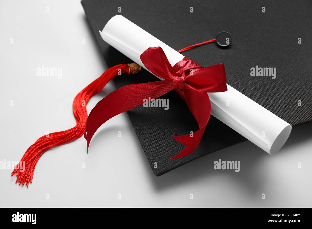 Diploma with red ribbon and graduation hat on white background Stock ...