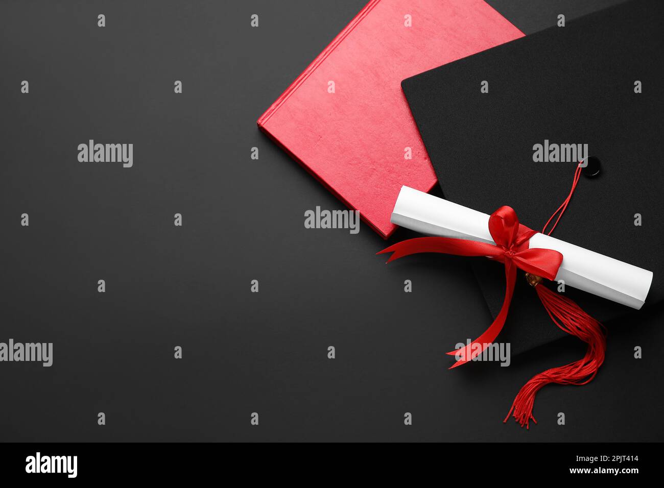 Diploma with red ribbon, graduation hat and book on black background ...