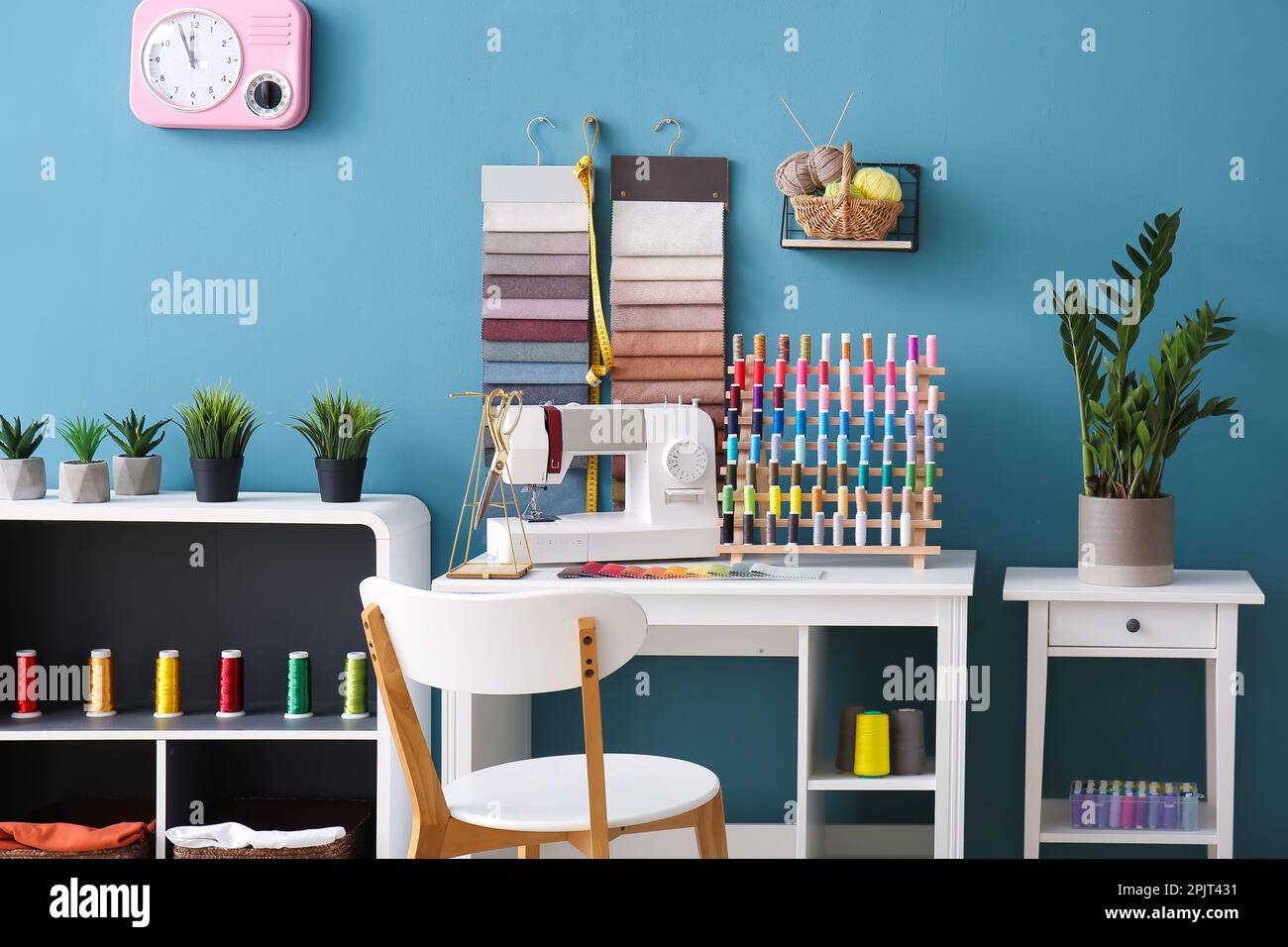 Interior of atelier with tailor's workplace, fabric samples and thread ...