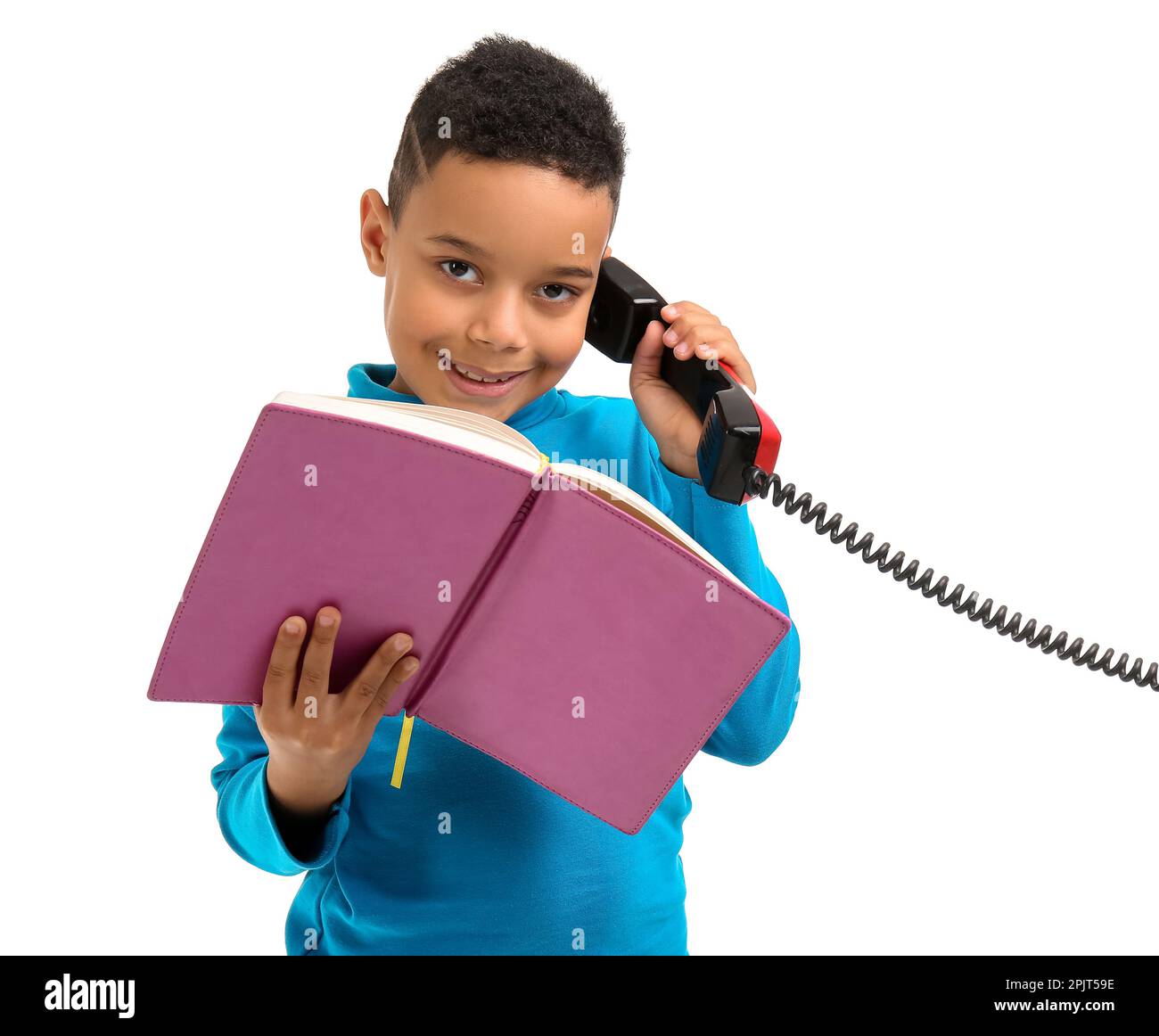 Little African-American boy with book talking by telephone on white ...