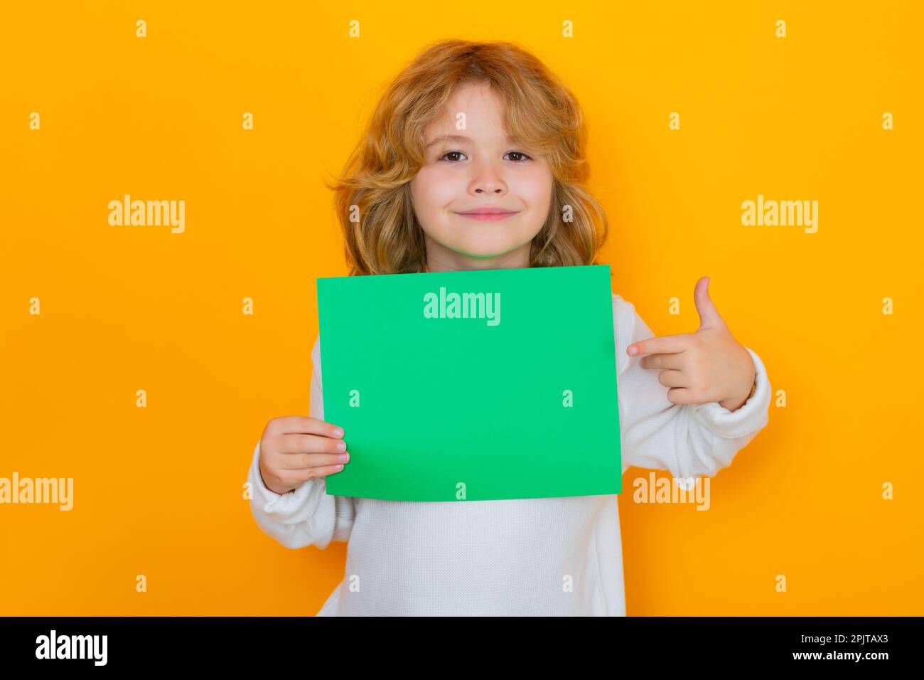 Kid showing index finger on green empty sheet of paper, isolated on ...