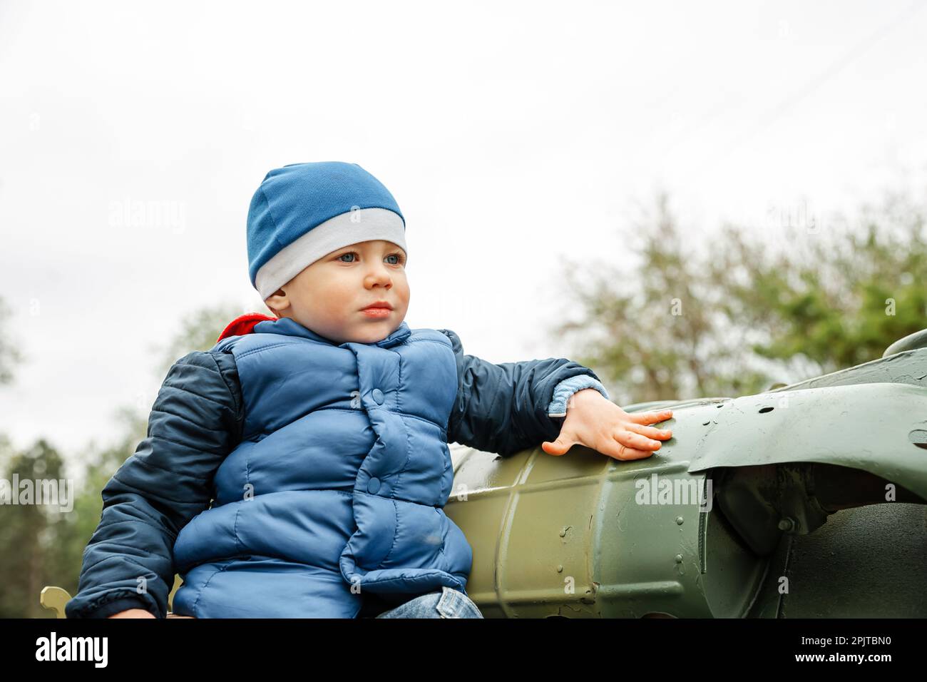 Boy playing military tank. Child explores old vintage military tank ...
