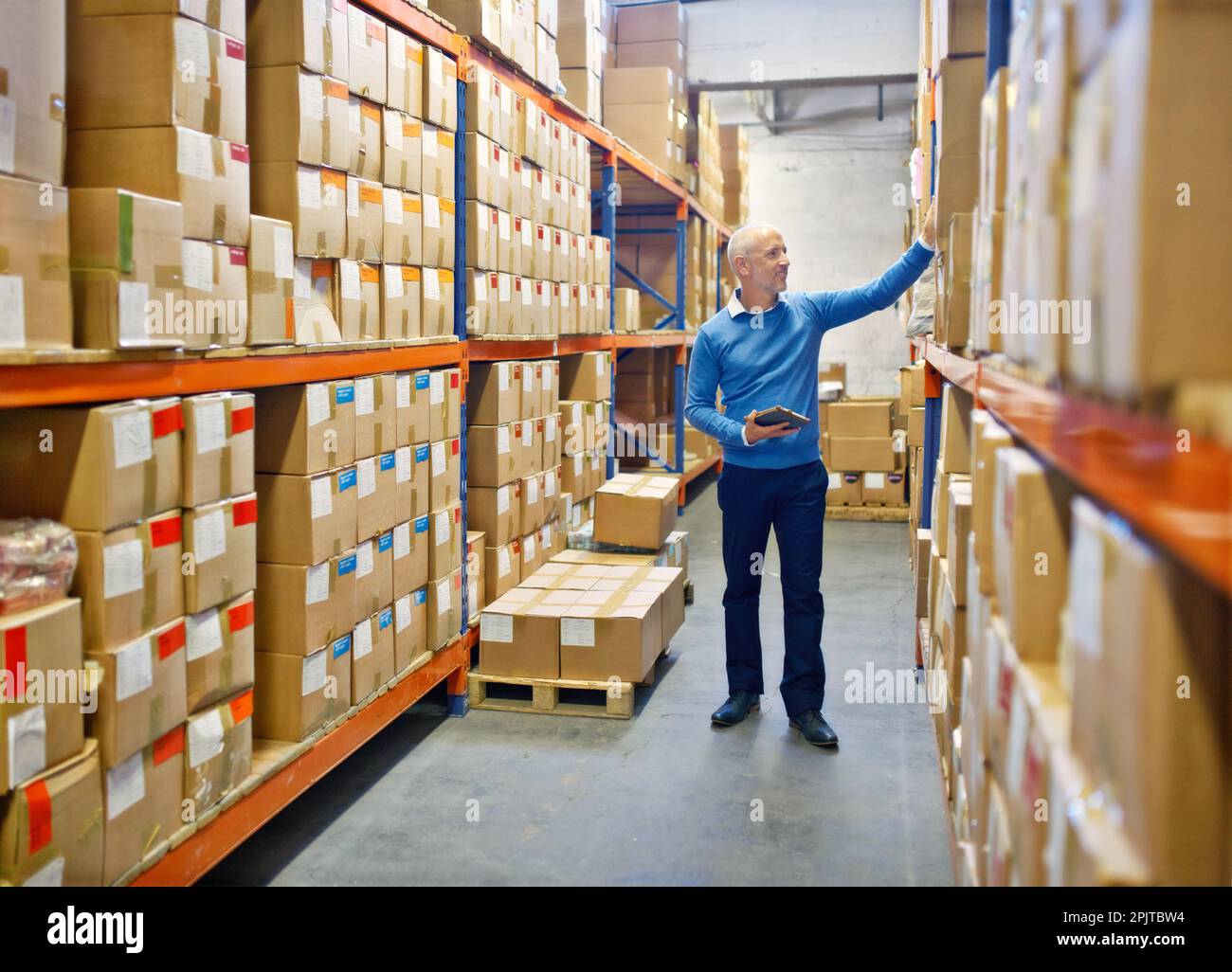 Making sure the warehouse runs well. A man doing an inventory check in ...