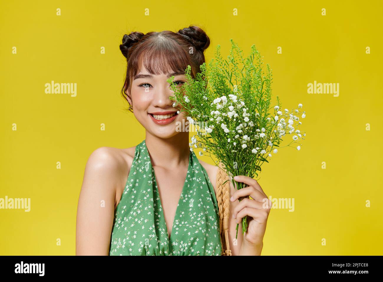 Portrait of an attractive young lady hands hold bouquet wild flowers ...