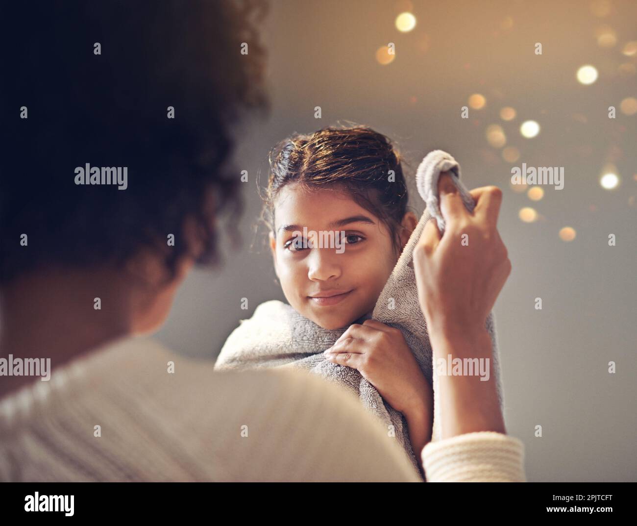 Squeaky clean after her bath. a mother drying off her daughter with a towel in the bathroom ...