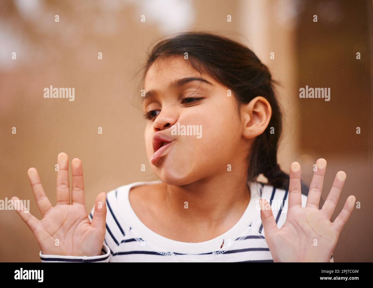 Childhood - license to be silly. a little girl pressing her hands and ...