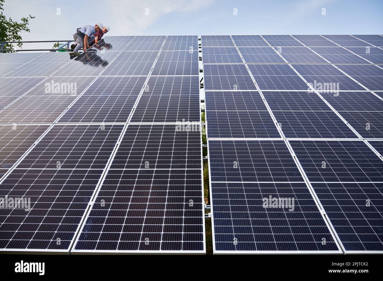 Male workers mounting photovoltaic solar panel system outdoors. Men ...