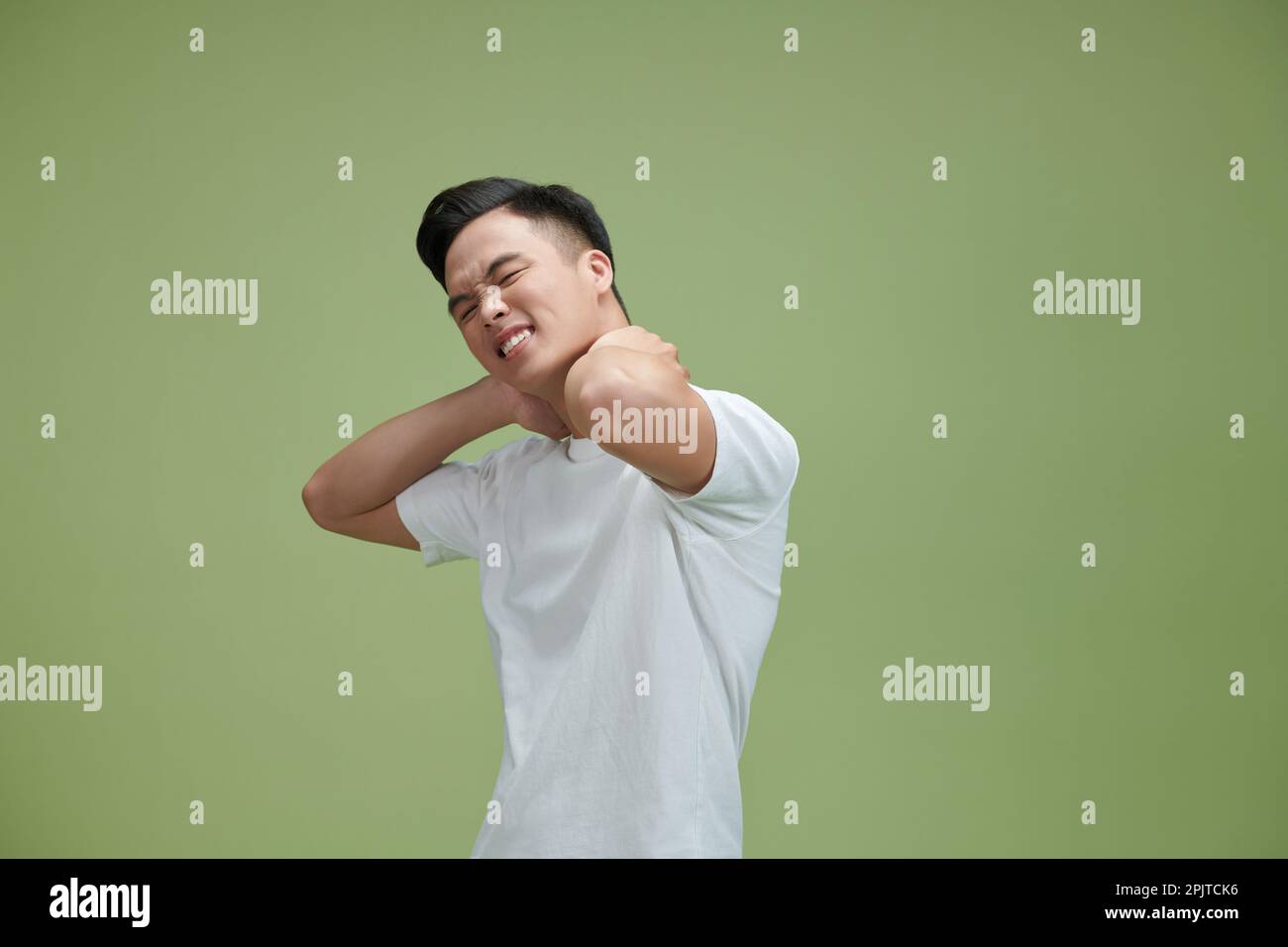 Young man suffering from neck pain, horizontal Stock Photo - Alamy