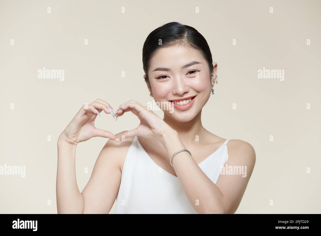 Portrait of positive young lady with healthy smooth skin holding hands ...