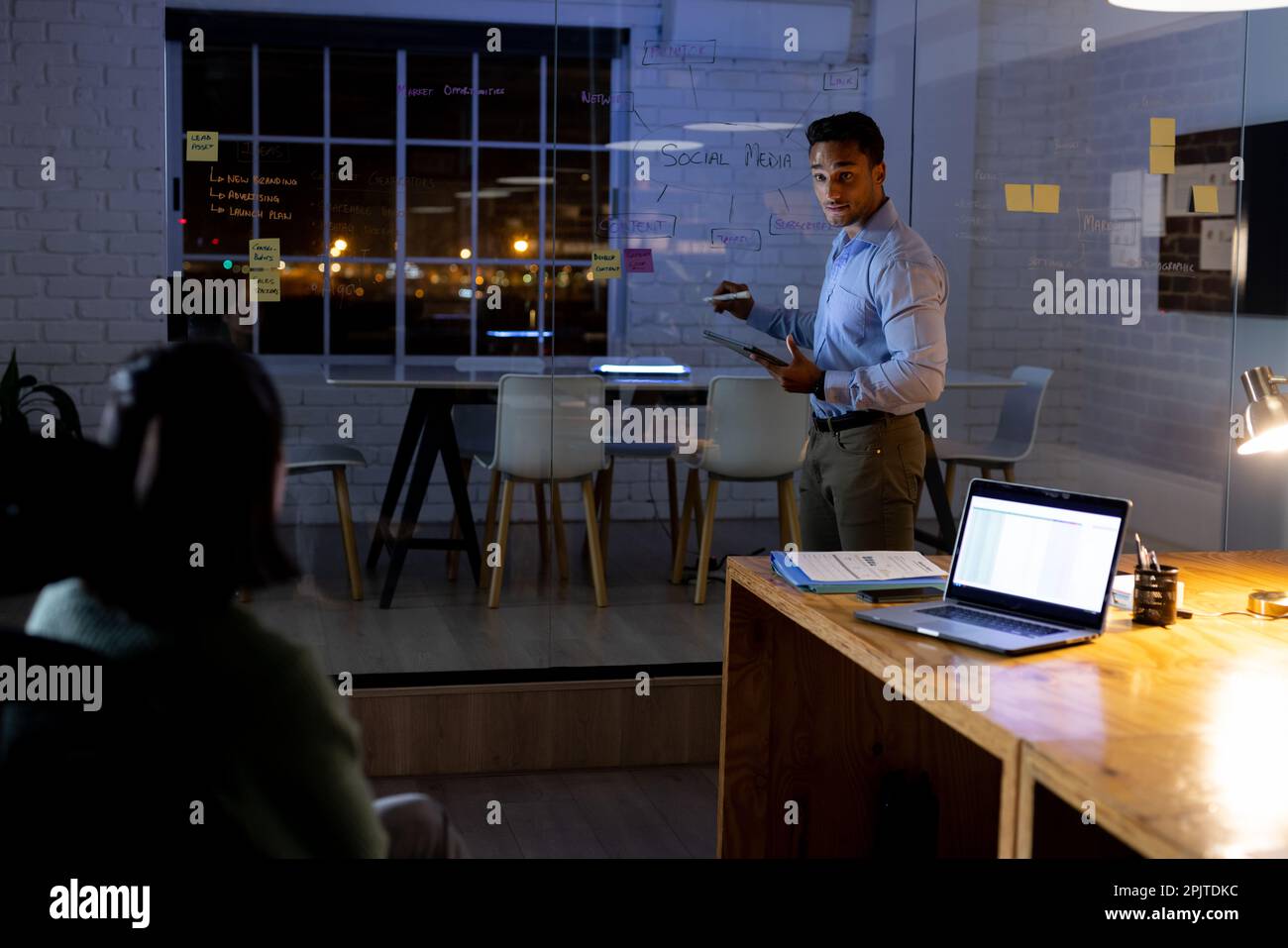 Diverse business people using tablet, making notes on glass wall ...