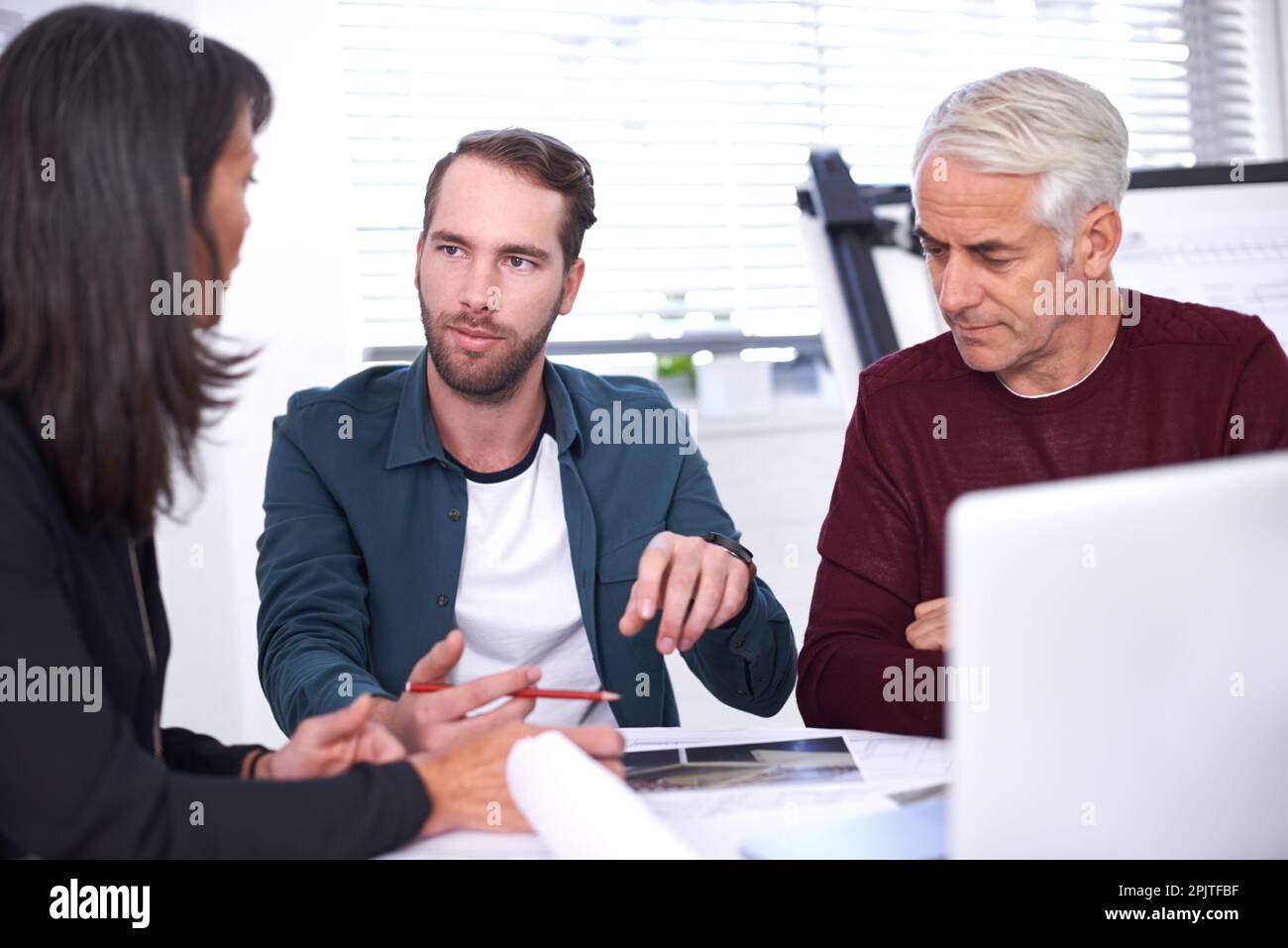 Discussing ideas for the new project. three architects working on a new ...