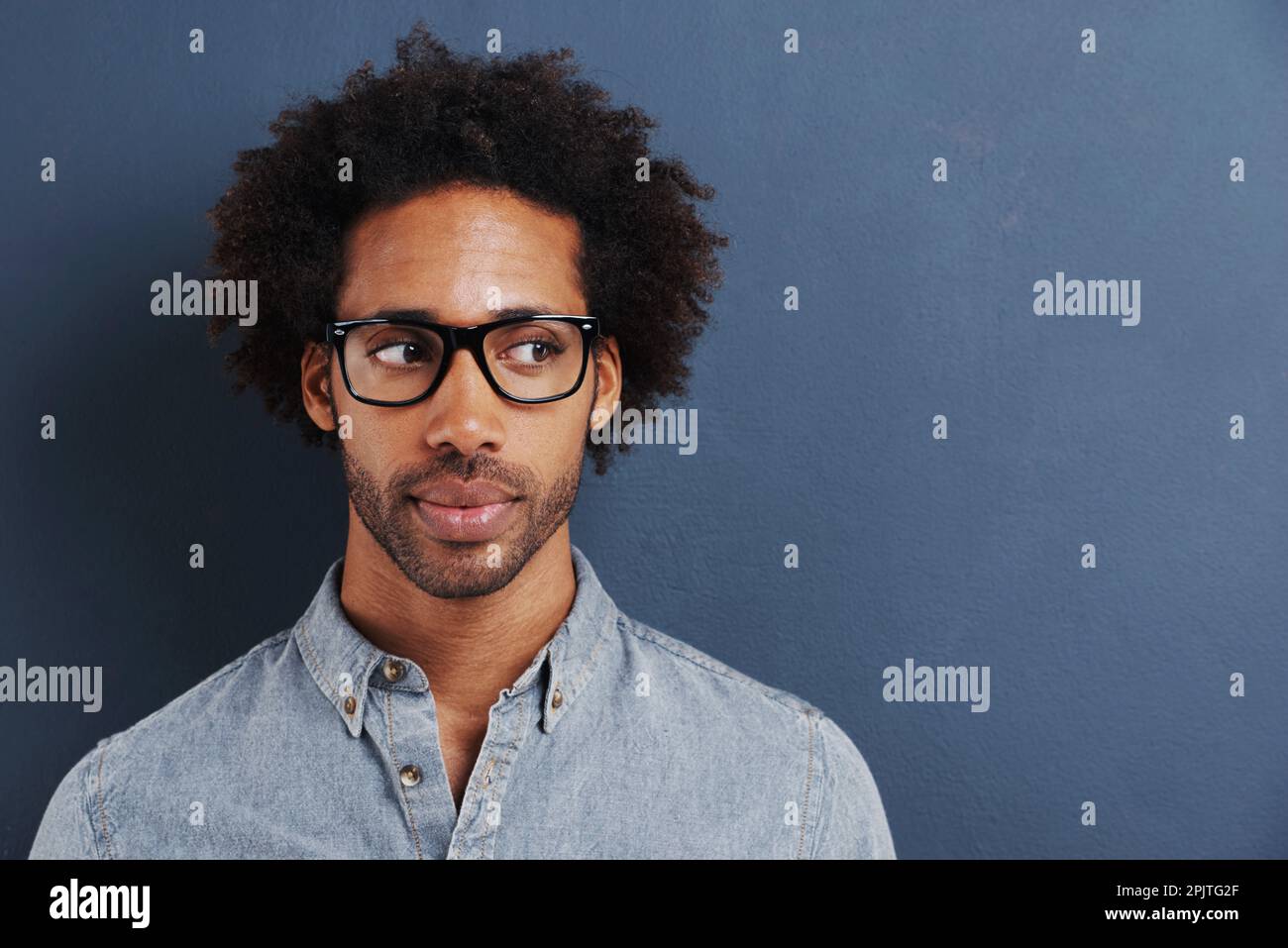 Thinking in progress...a handsome young man wearing glasses glancing ...