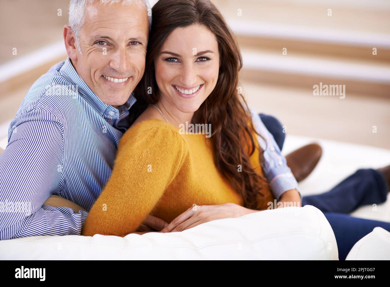 Content at home together. A happy couple sitting together on their ...