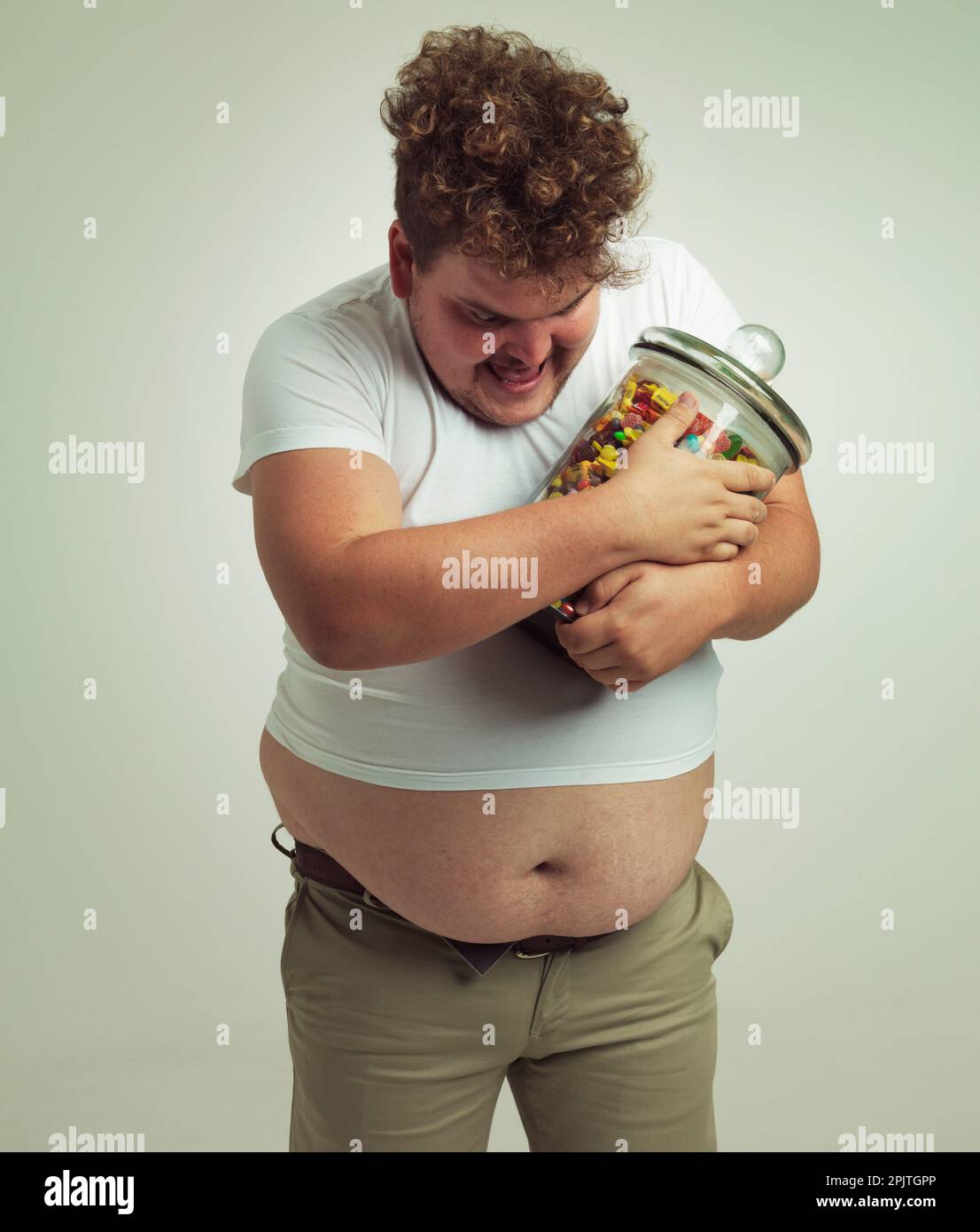 Candy makes me happy. an overweight man holding a large jar of candy ...