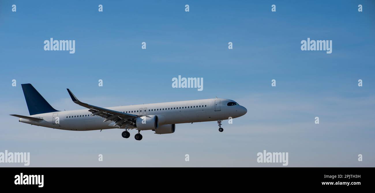 Side view of an airplane landing against a blue sky. Widescreen Stock ...