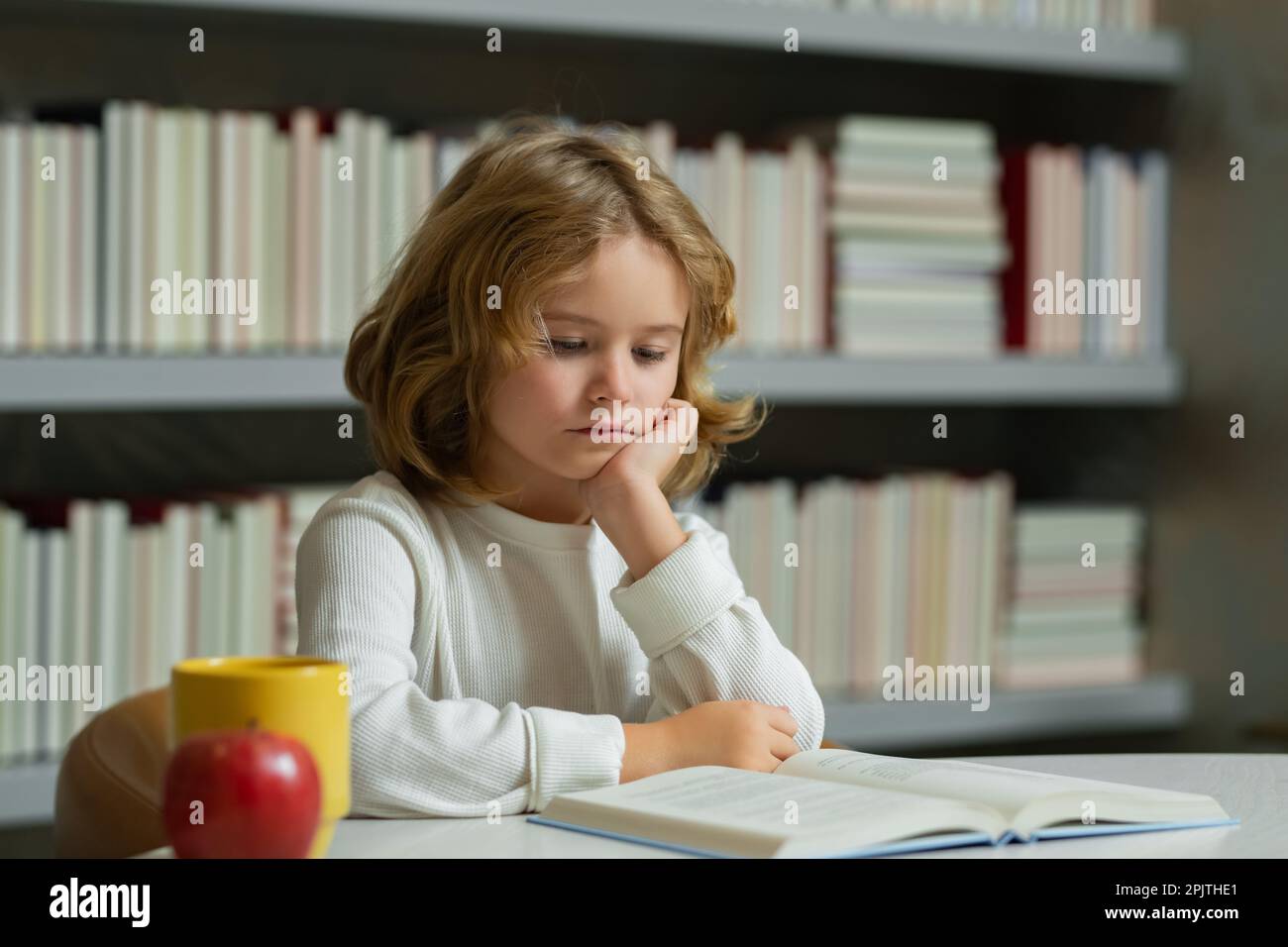 Smart pupil. Schoolboy reading book in library. Kids development, learn ...