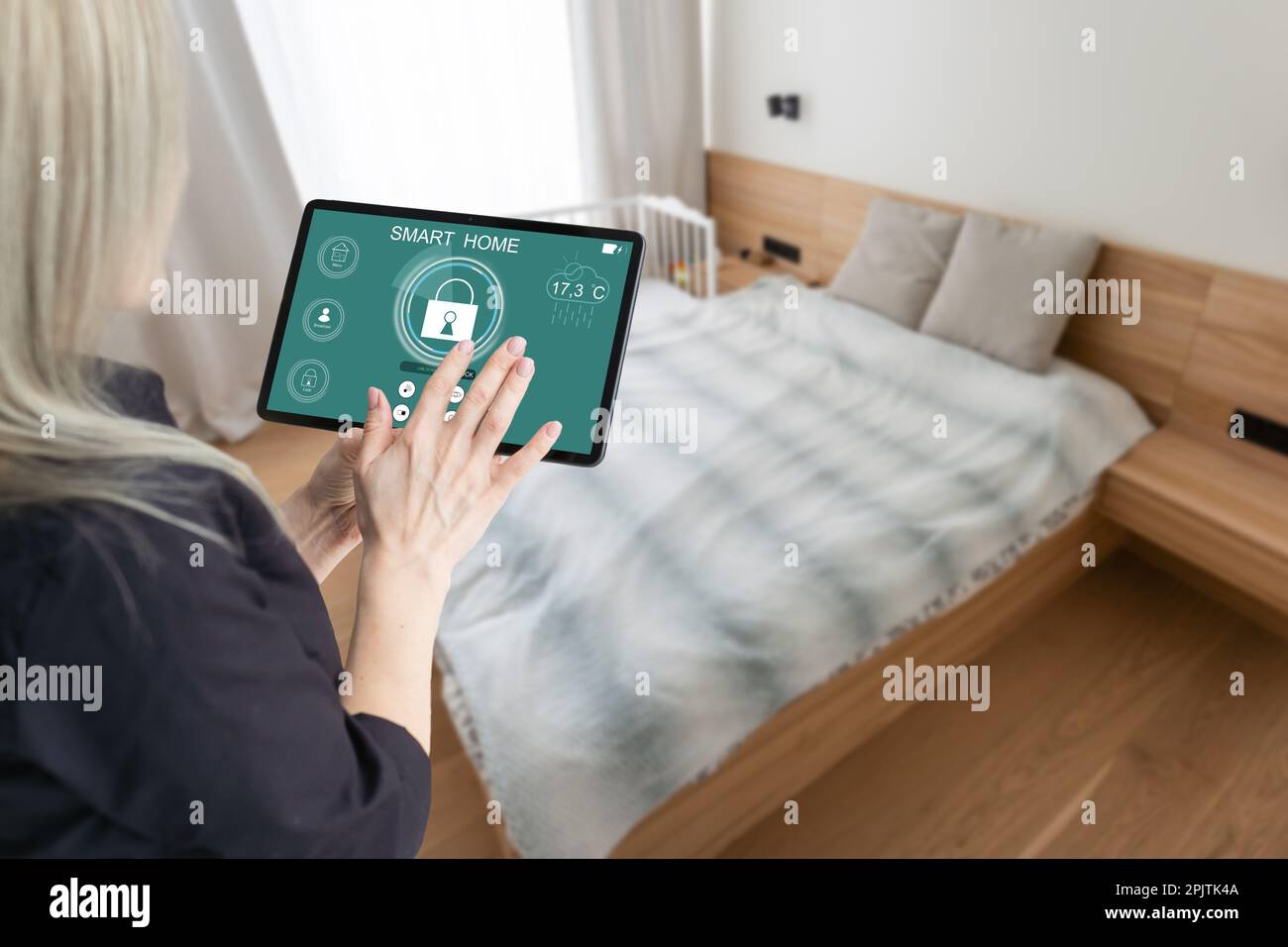 Side view pleasant young woman using smart home system or activating ...