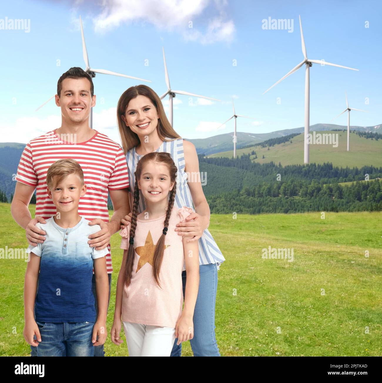 Happy family with children and view of wind energy turbines on sunny ...