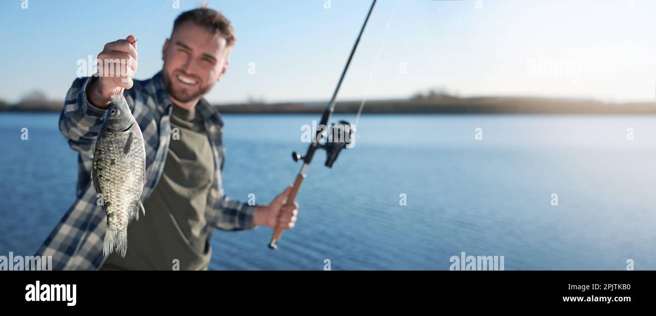 Fisherman with fishing rod at riverside, space for text. Banner design ...