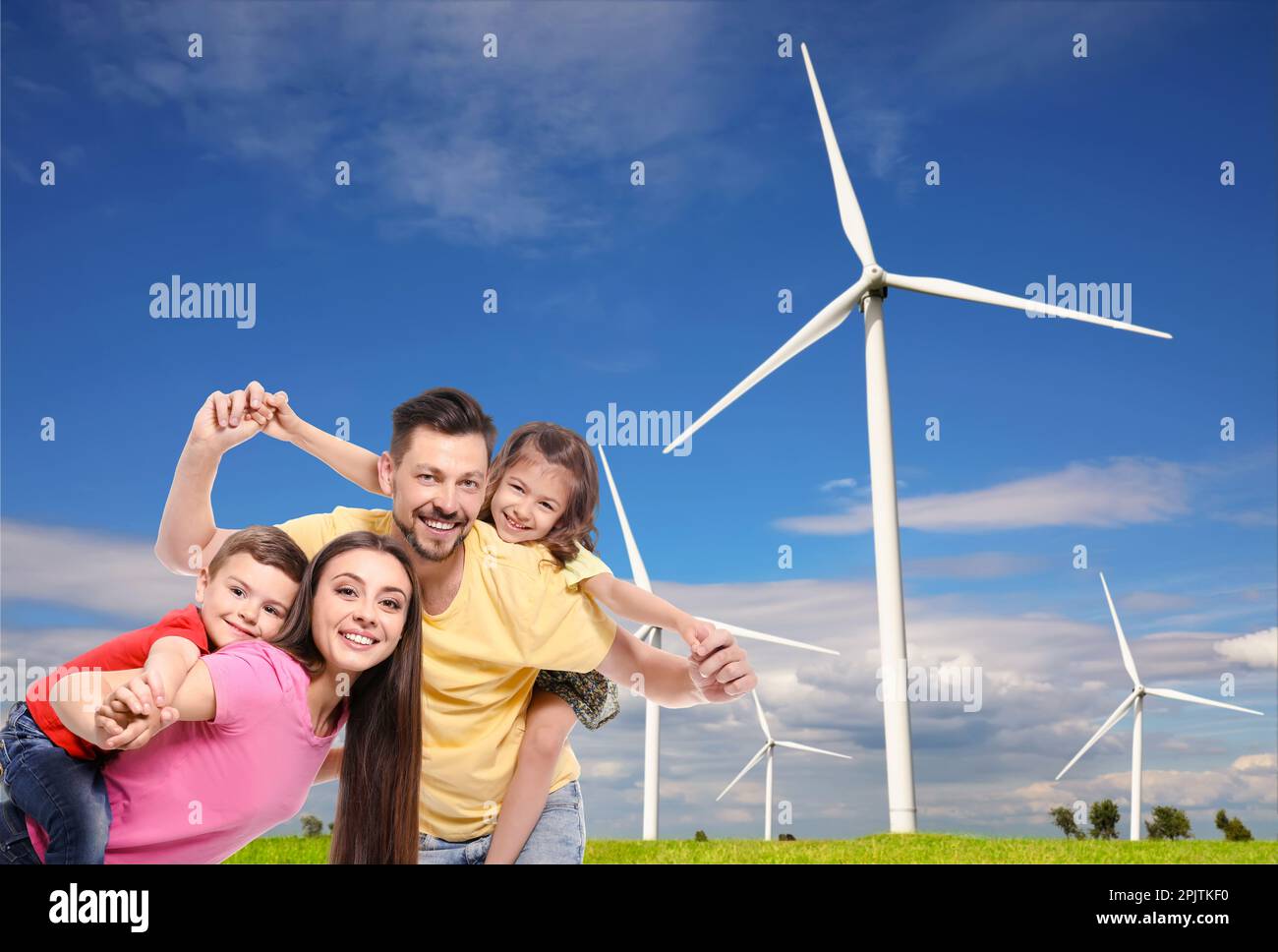 Happy family with children and view of wind energy turbines on sunny ...