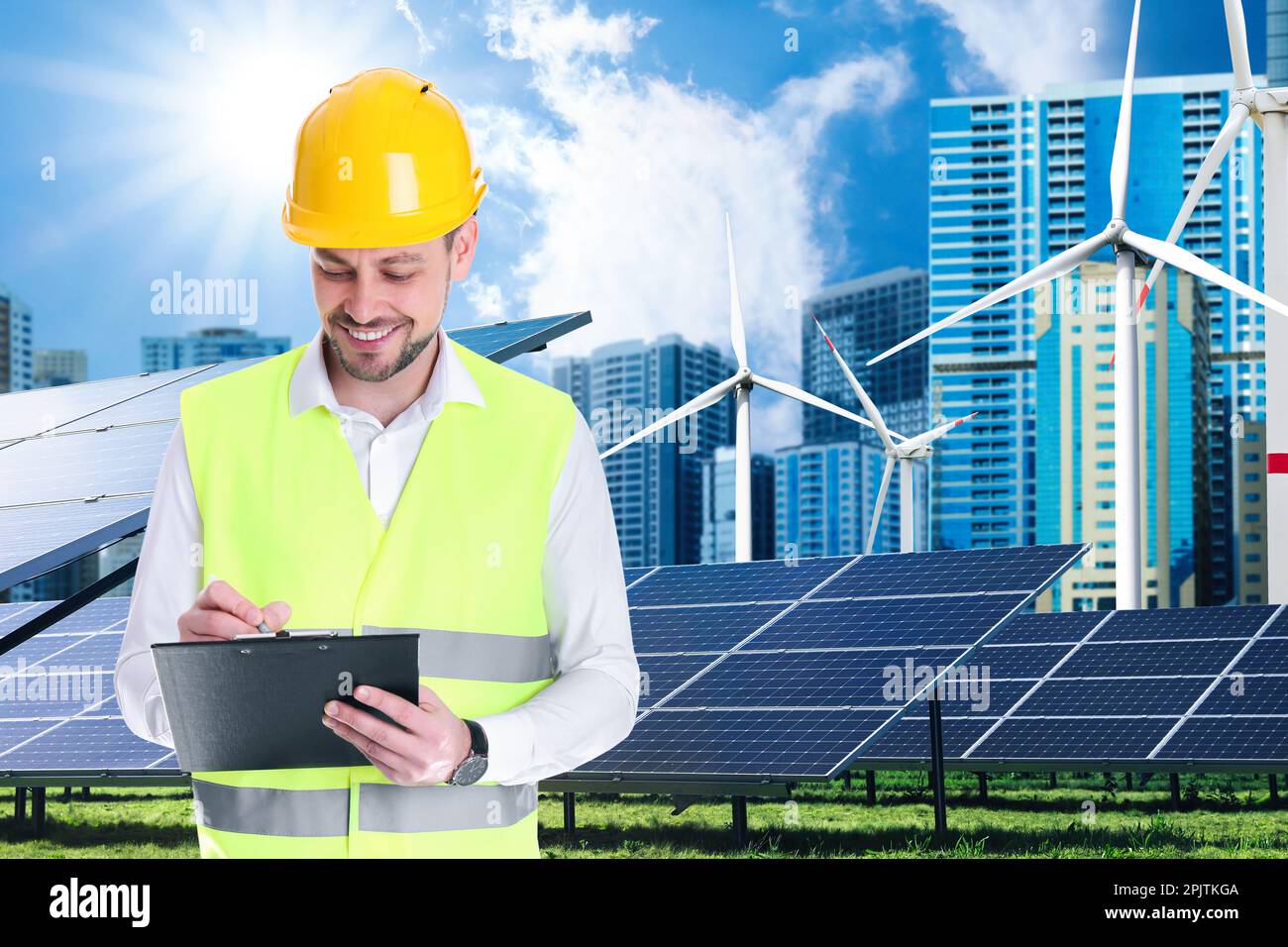 Industrial engineer in uniform and view of solar panels and wind energy ...